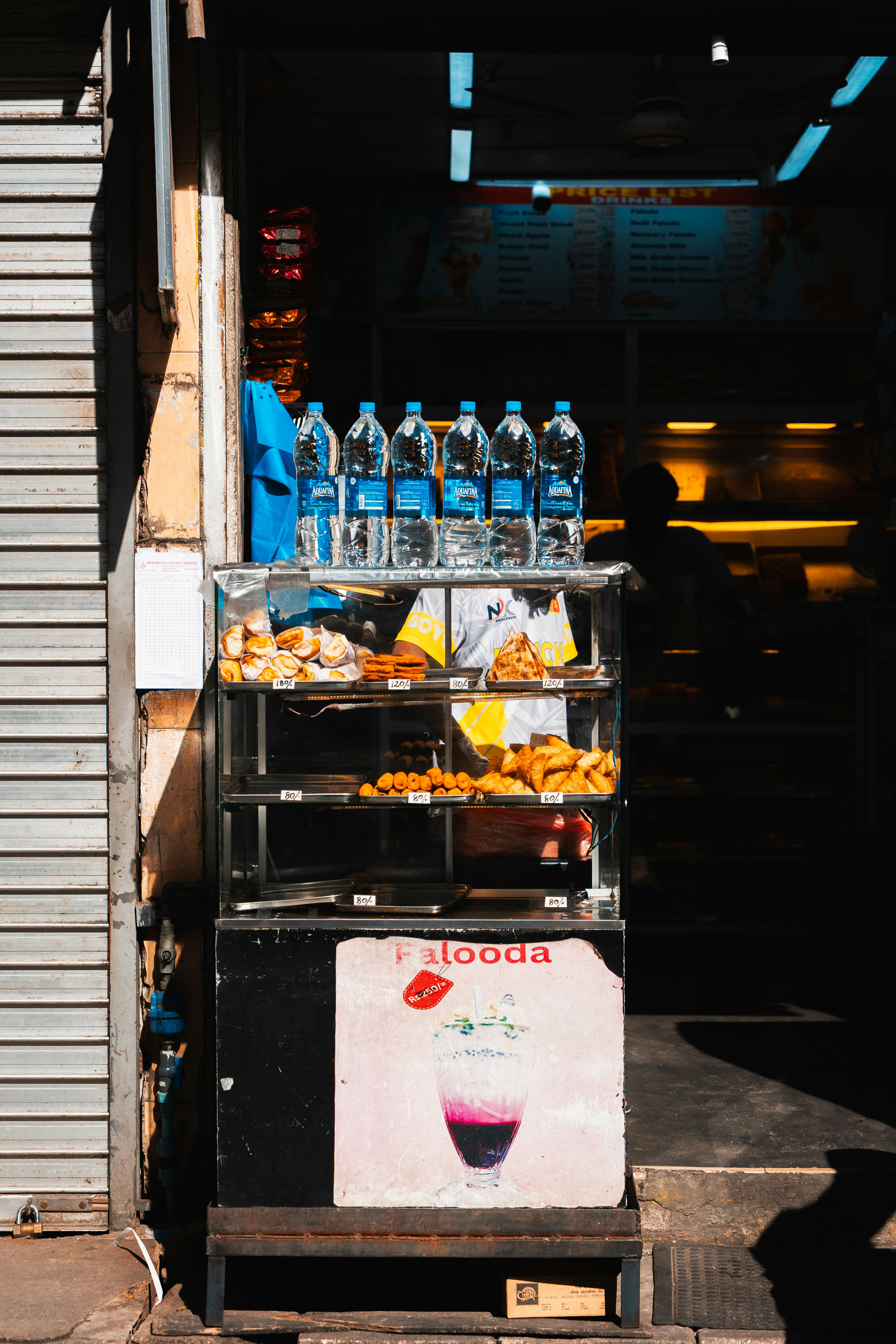 Neon Snack Stand: Bottled Water and Fried Treats in a Dim Shopfront