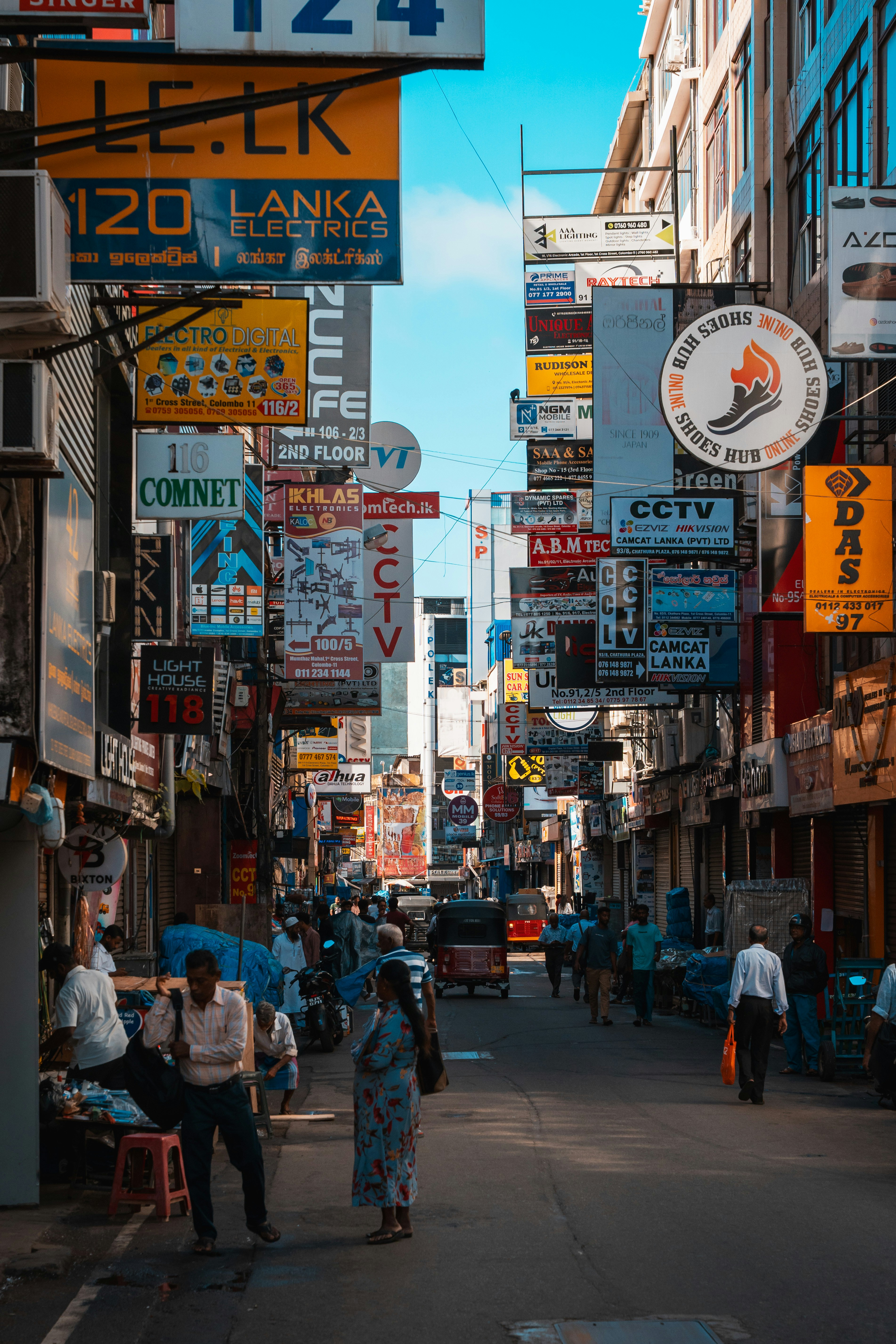 Neon Alleyways: A Street Canyon of Signs and Shoppers