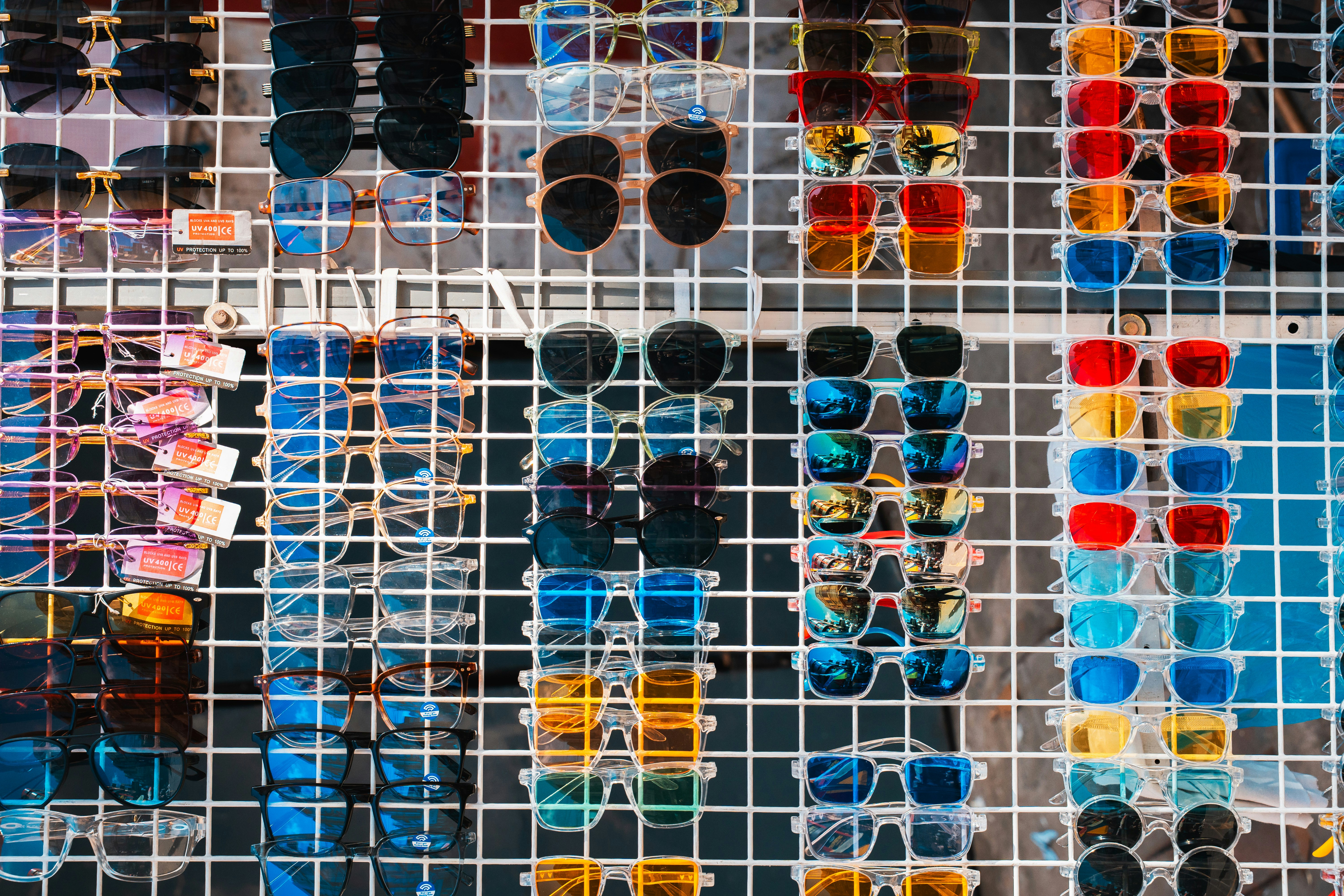 Vibrant Grid of Sunglasses: A Colorful Display of Sunwear in a Storefront