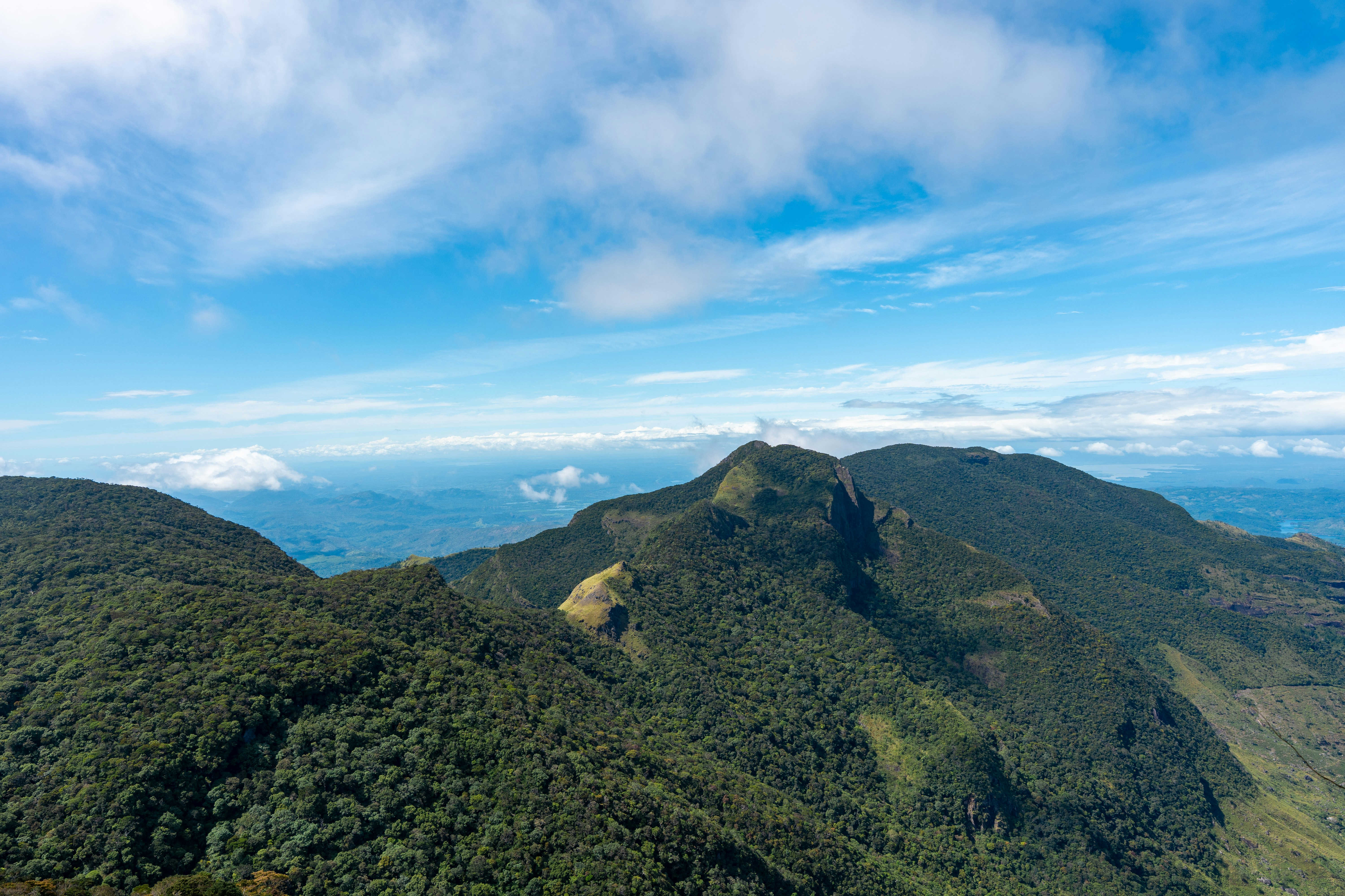 Verdant Ridge Overlook: Aerial View of Layered Peaks Under A Wide Sky