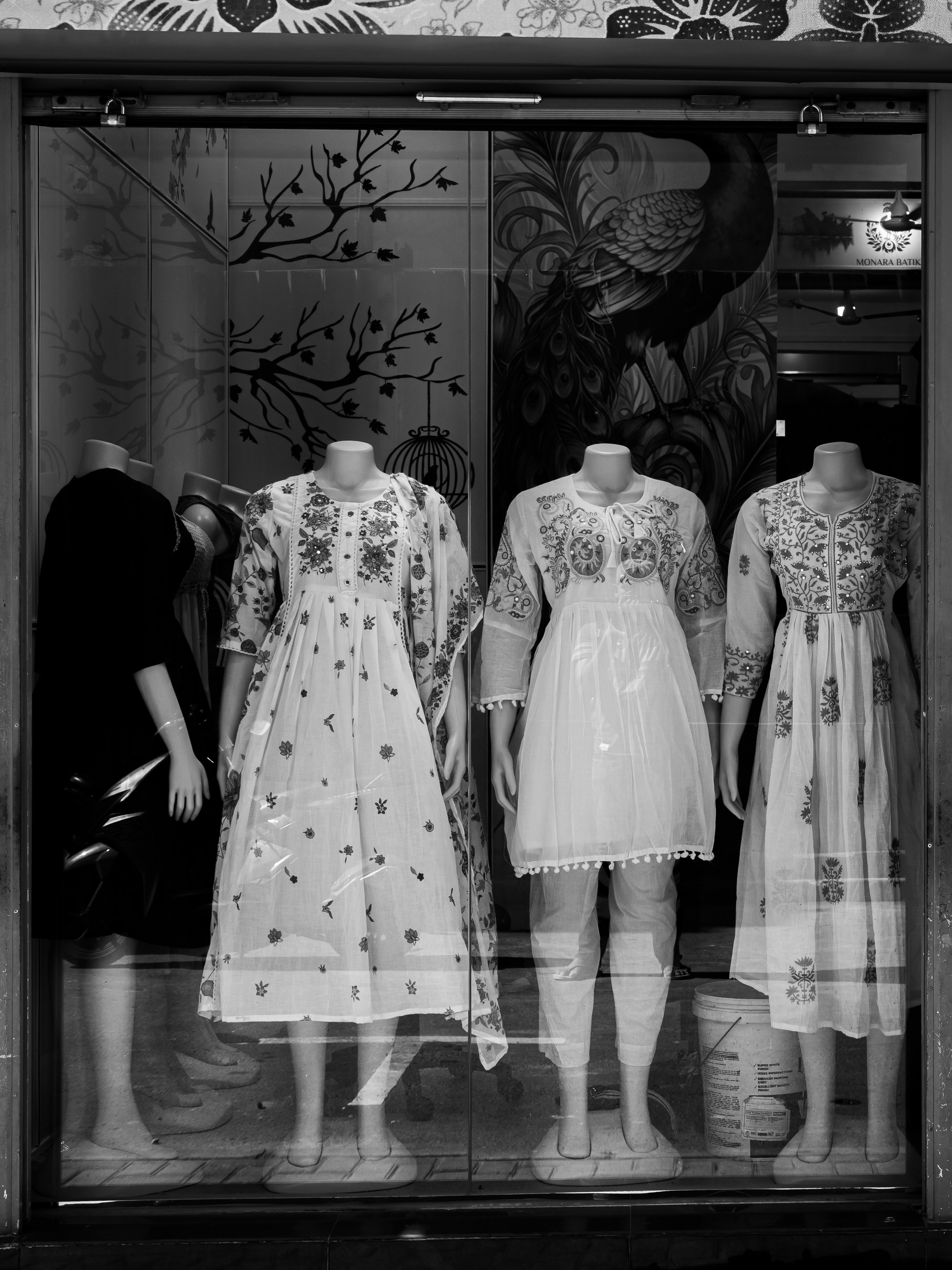 Silent Display: Mannequins Adorned in White Lace Against Painted Backdrop