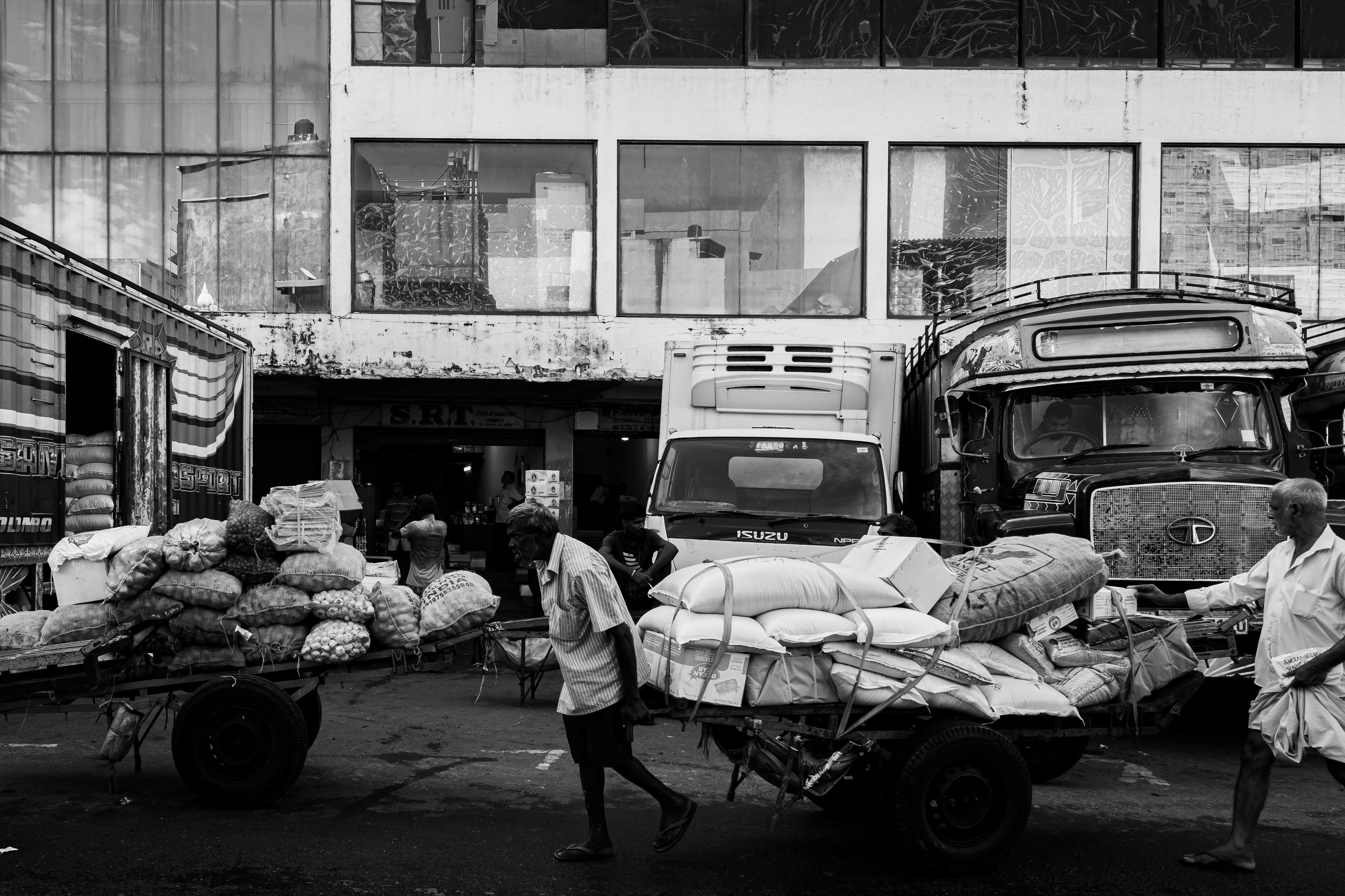 Market Trucks and Vendors in a Busy Black-and-White Scene