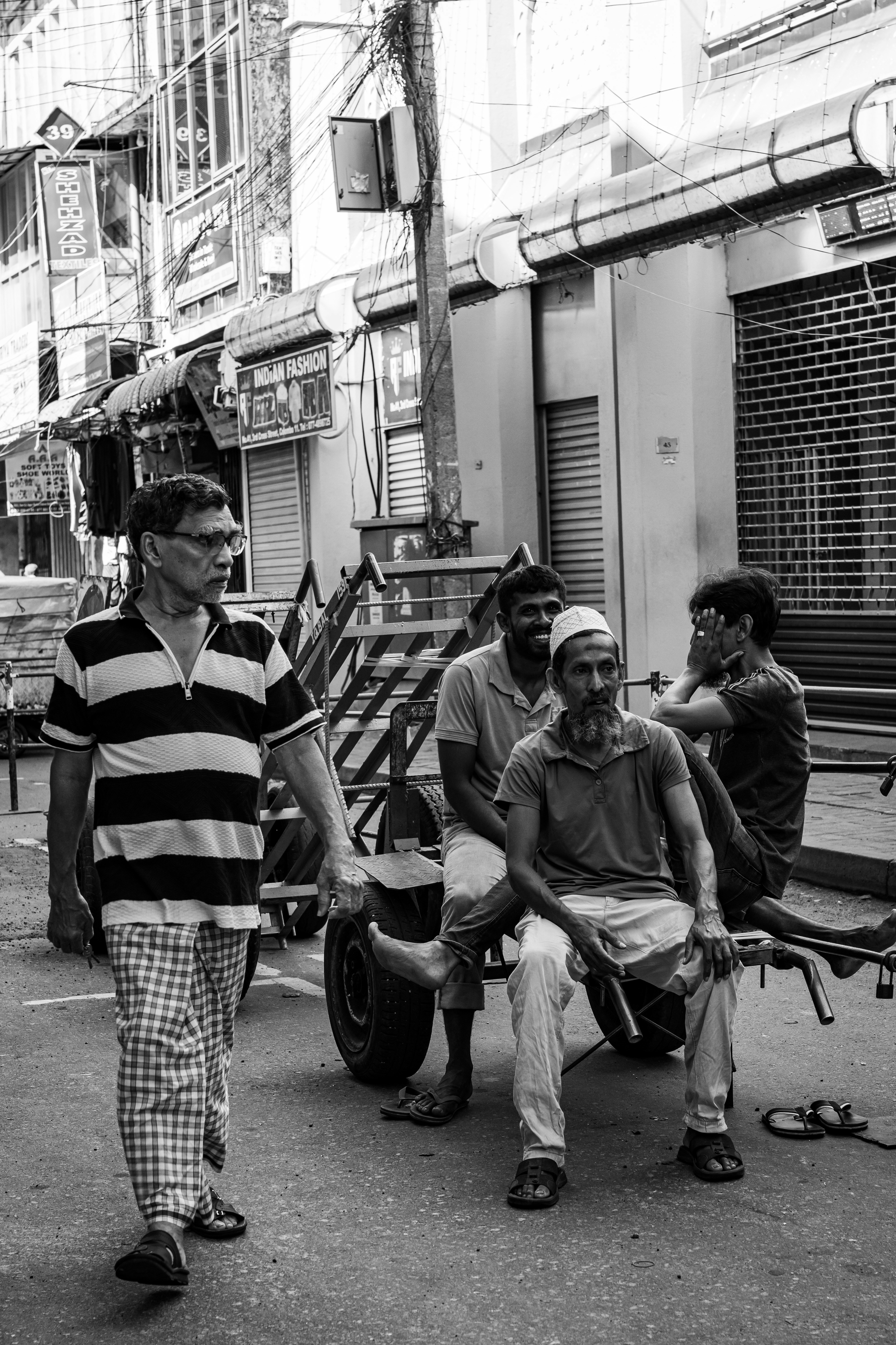 Smiles on Wheels: Neighbors Share a Moment in a Bustling Street