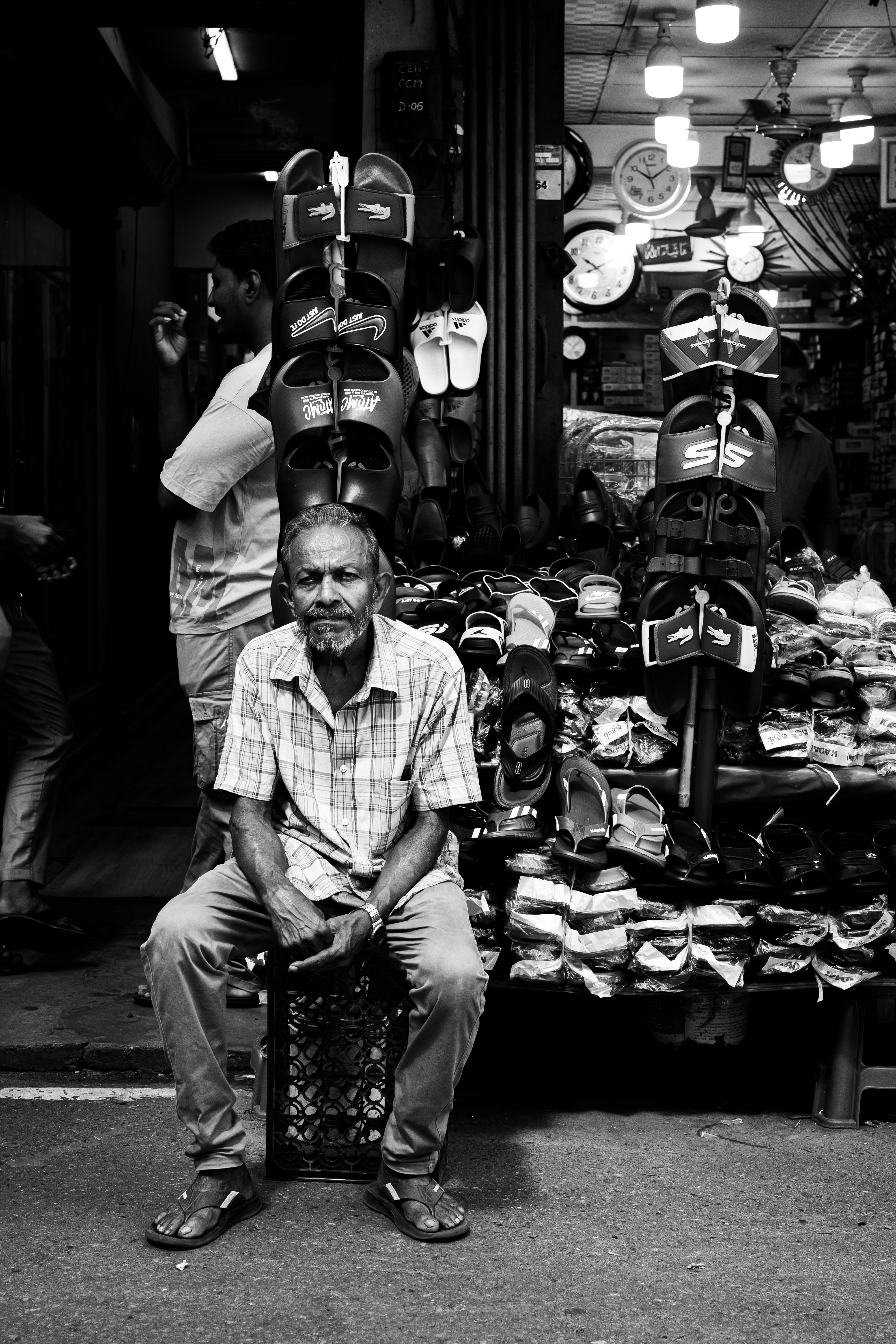 Stoic Shoe Merchant Beneath a Heap of Sandals