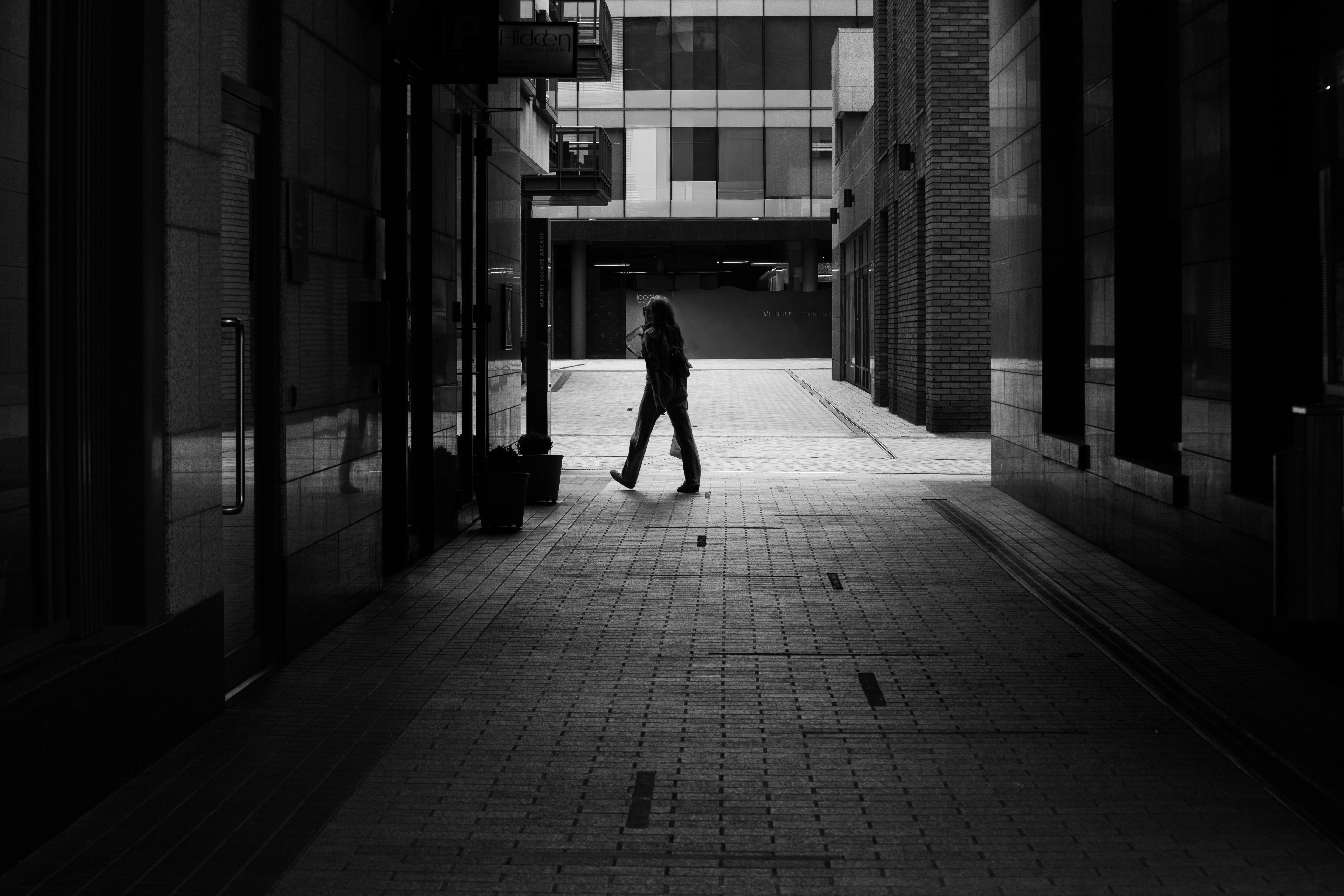 Footstep in a Quiet Atrium: A Solo Wanderer in a Black-and-White Corridor