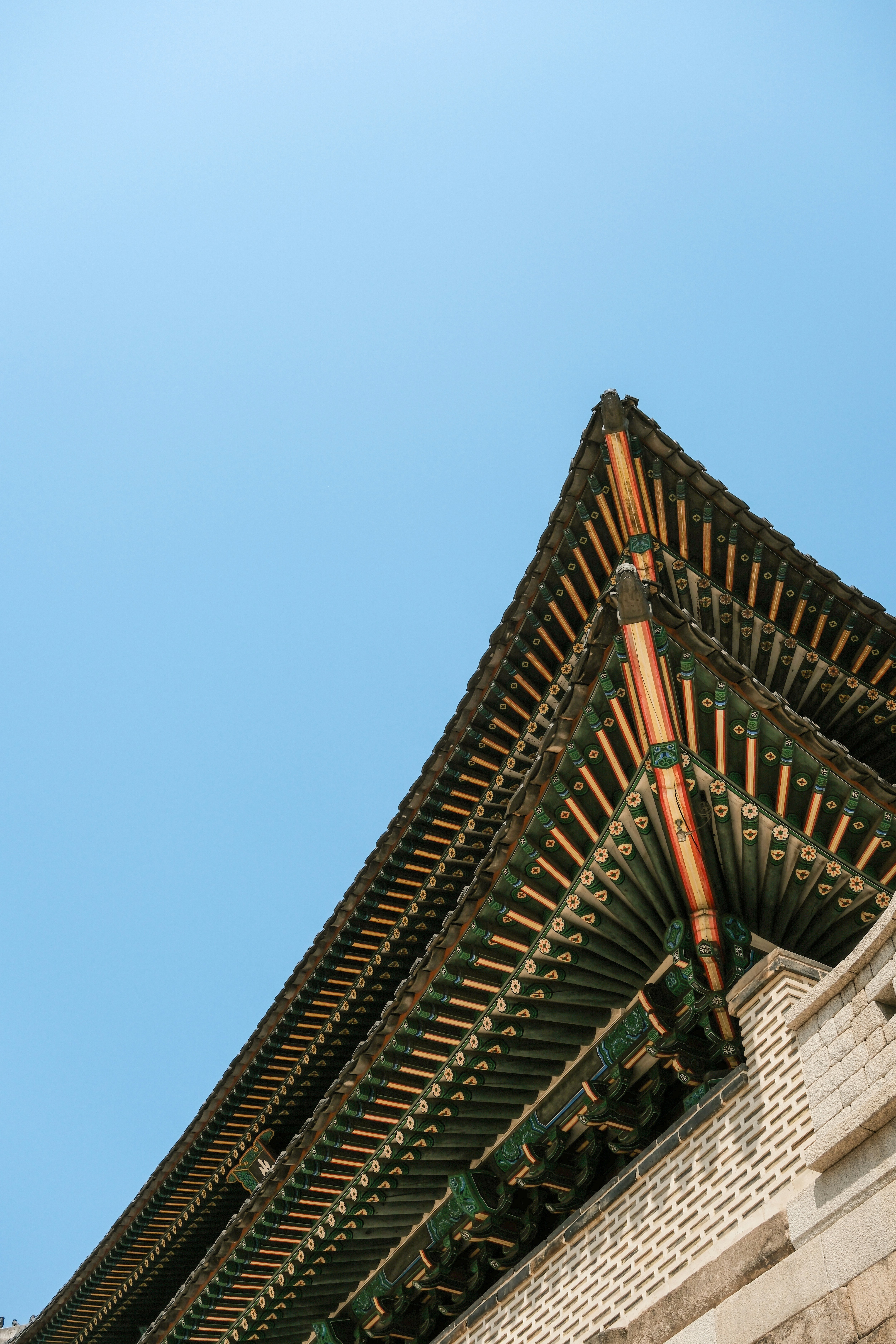 Angle of Grace: A Corner of Historic Eaves Against a Clear Sky