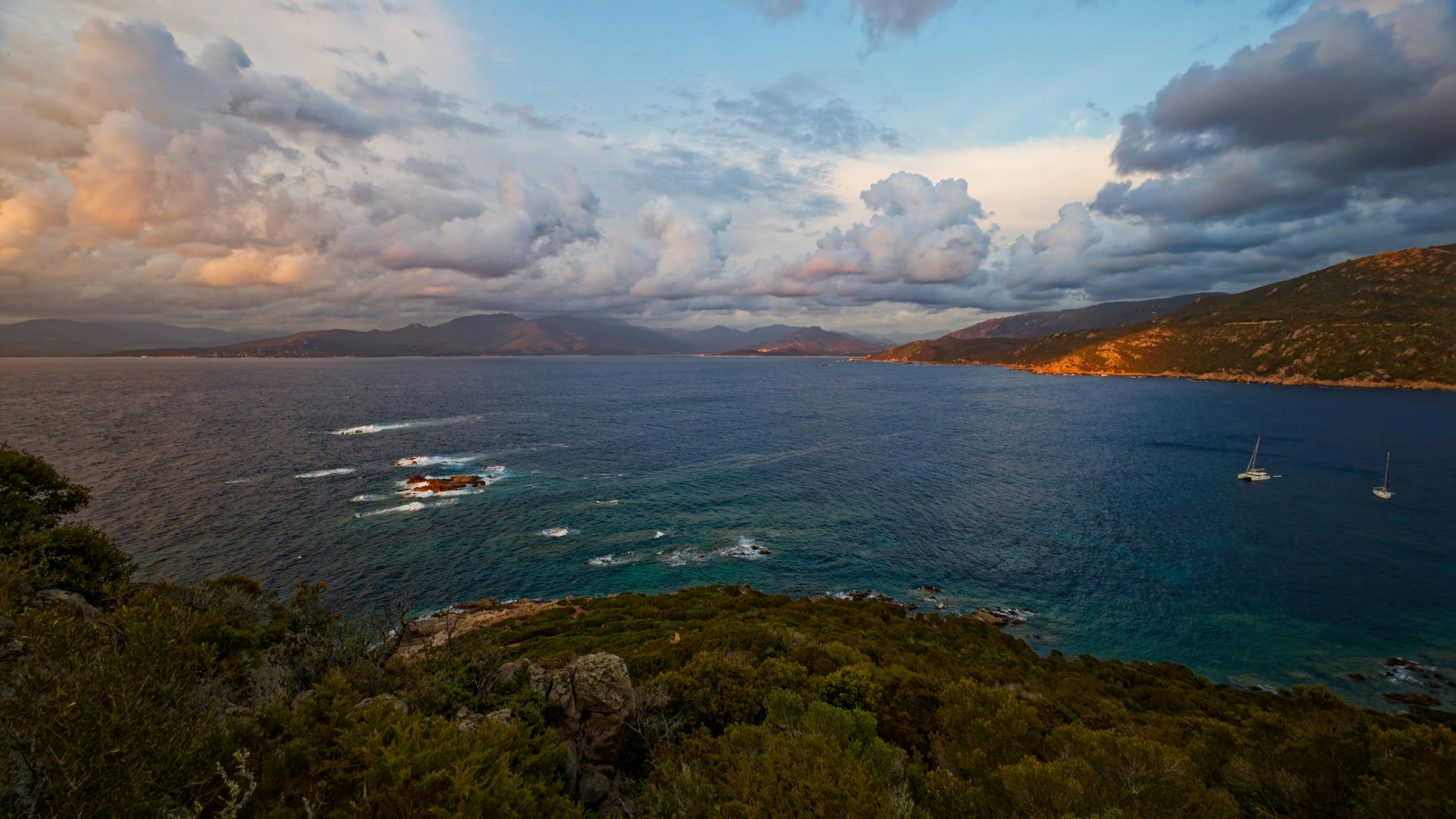 Sunlit Cove: Boats, Waves, and Distant Hills