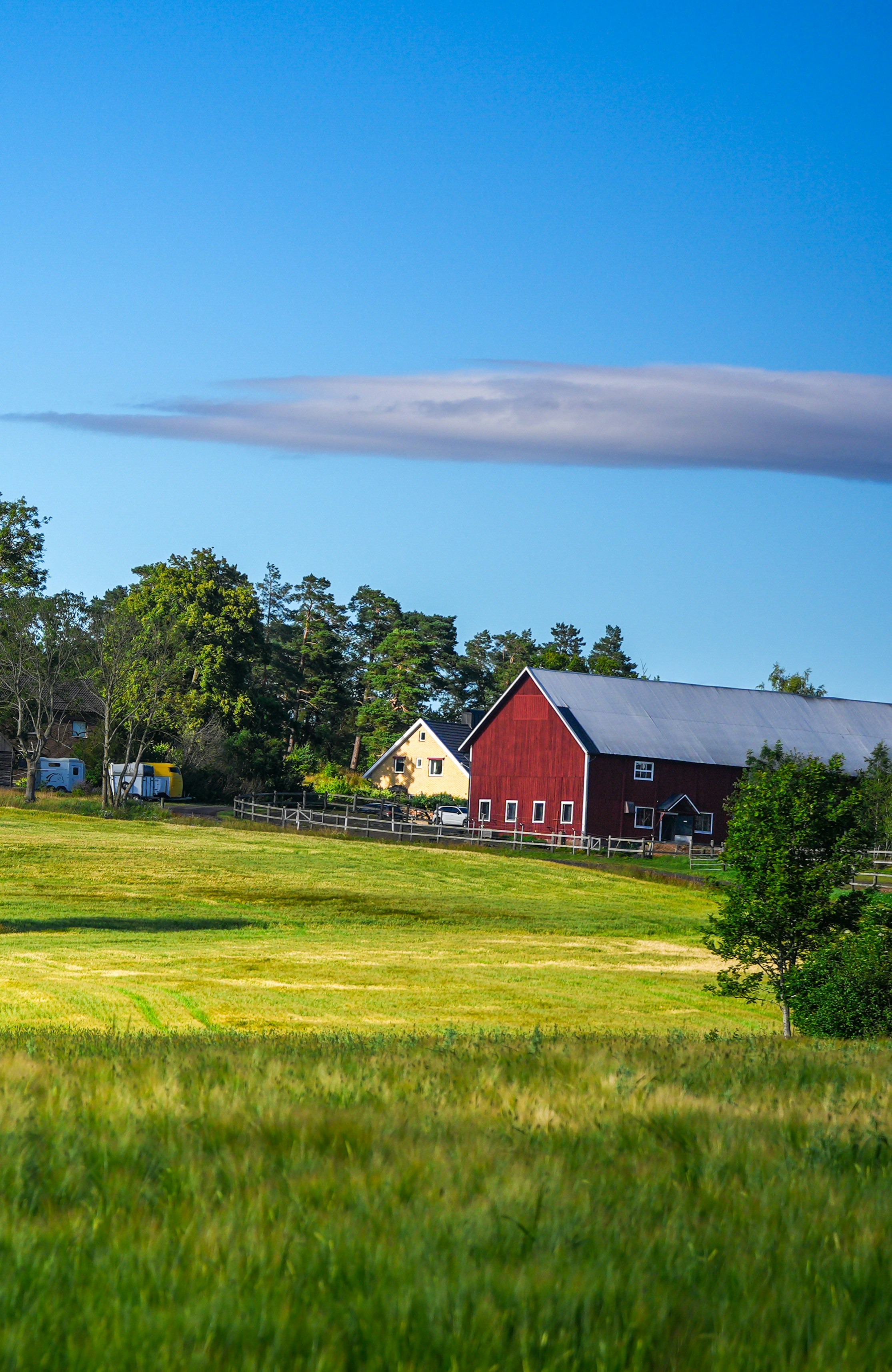 Red Barn on the Horizon under a Wide Blue Sky