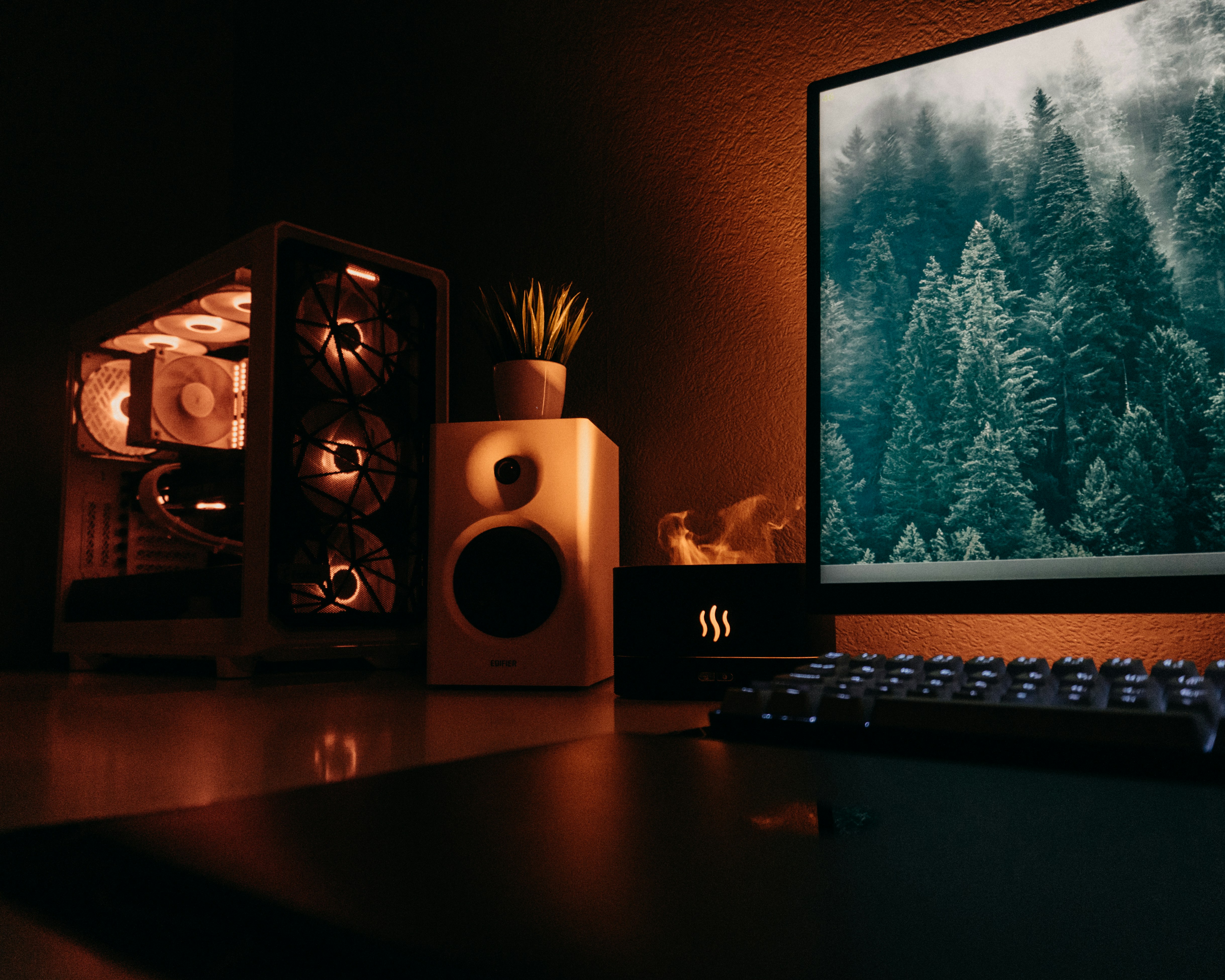 Dimly Lit Tech Nook: A Glowing Desktop Under Warm Amber Light
