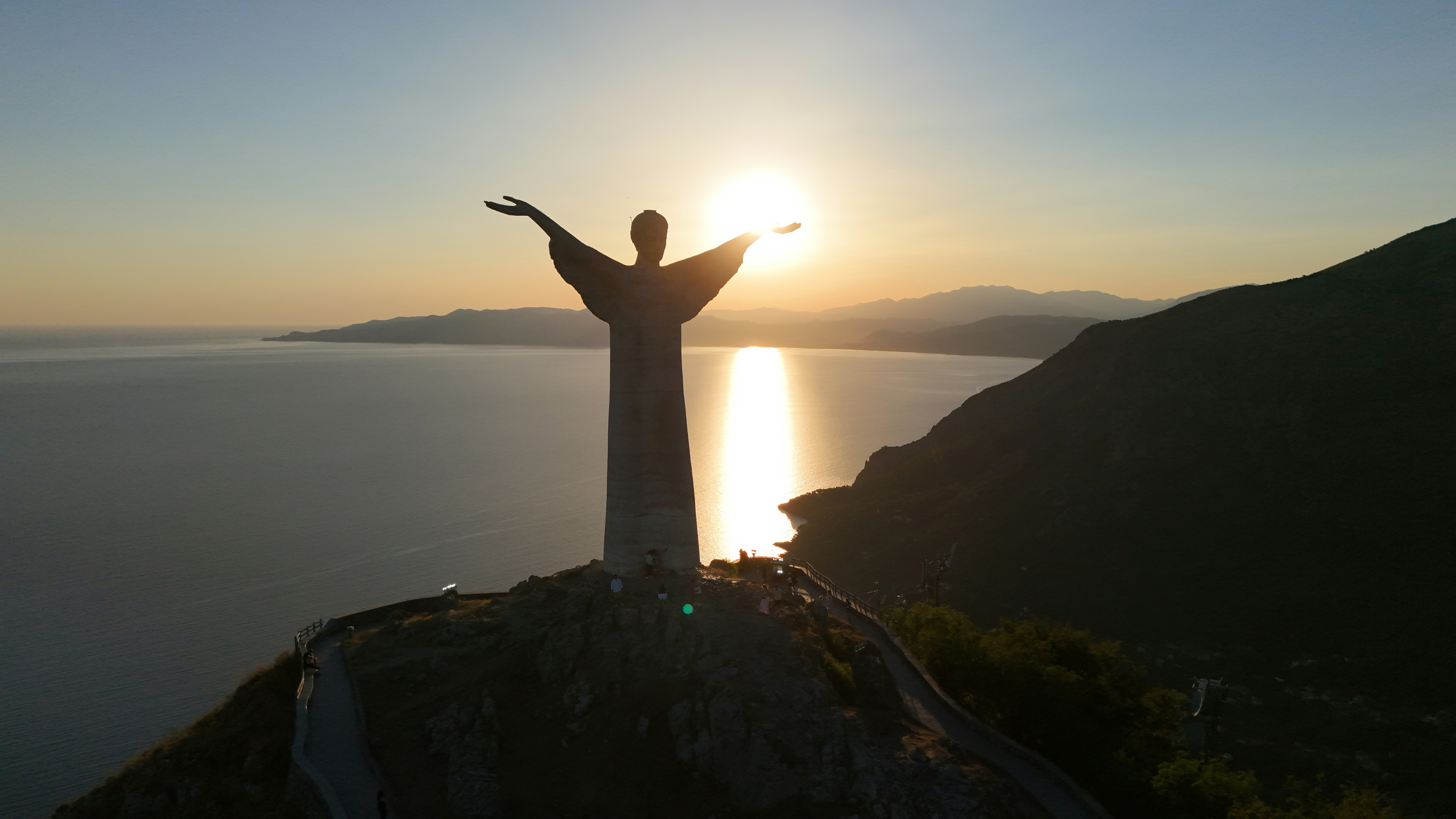 Sunlit Triumph: The Torch of Beginnings on a Cliff