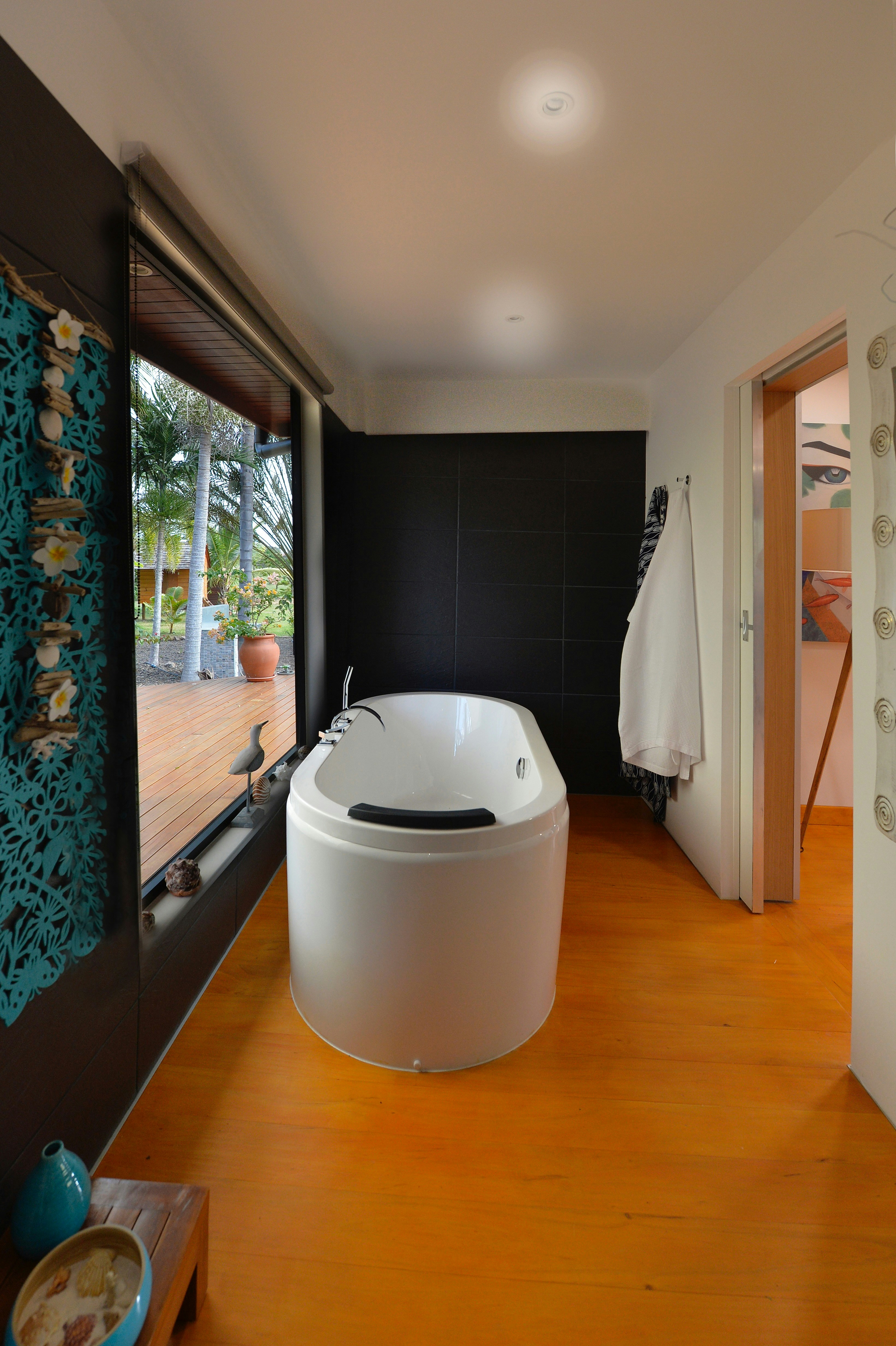 Floating Oasis: A Porcelain Bath Framed by Dark Tiles and Light Wood