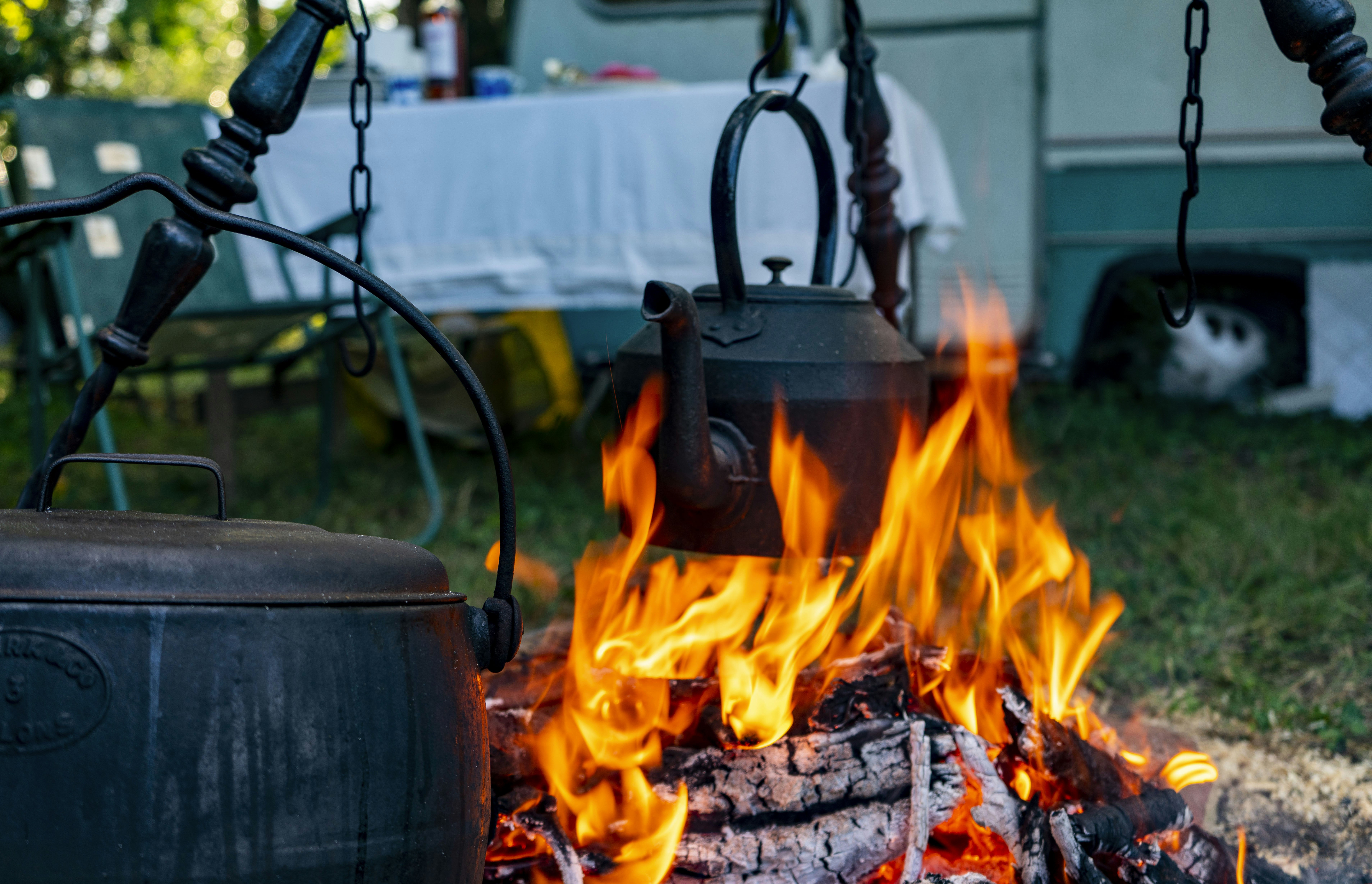 Flames and Teapot Over a Campfire: A Rustic Outdoor Moment