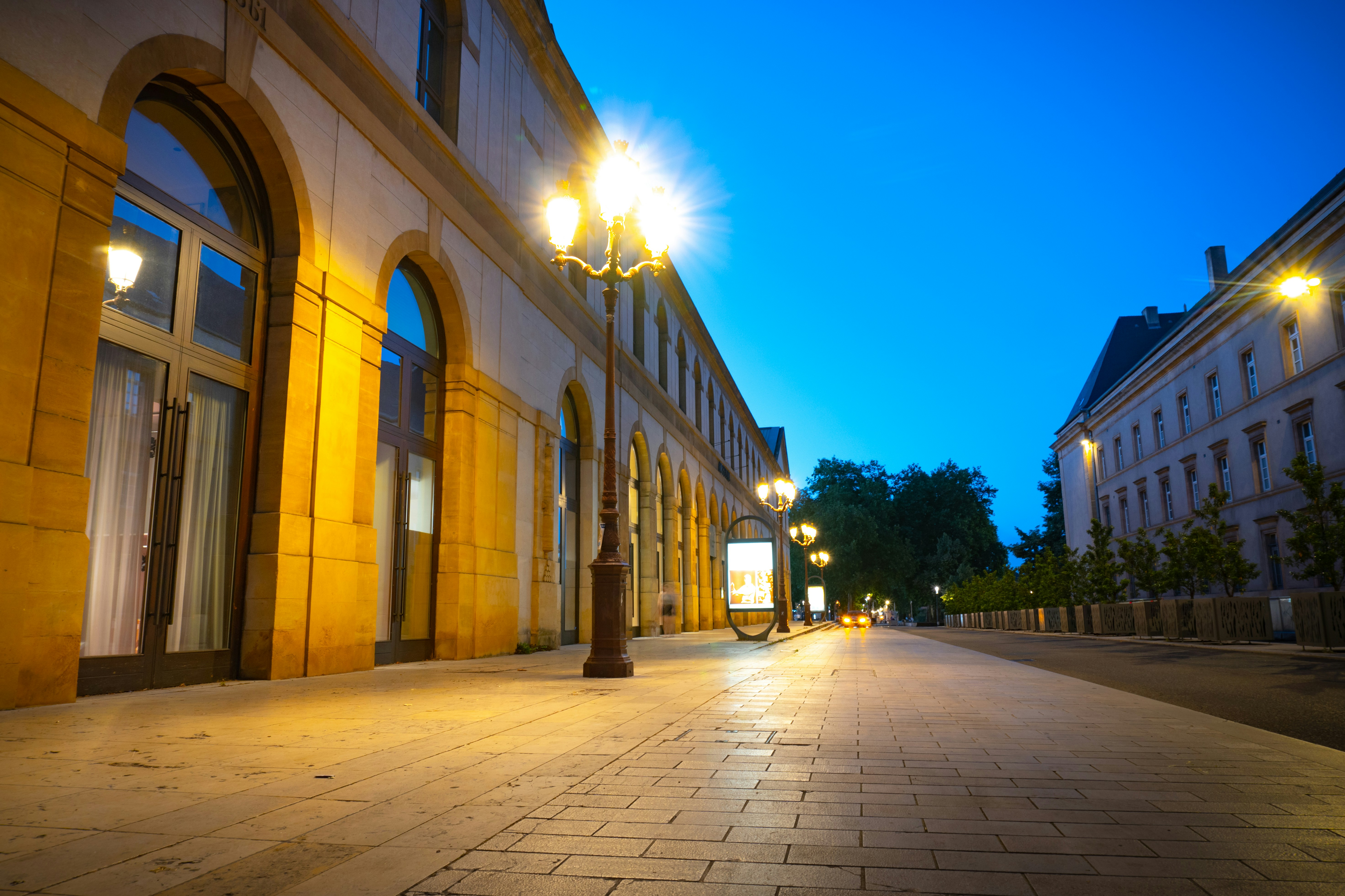Empty boulevard of warm arches at blue hour