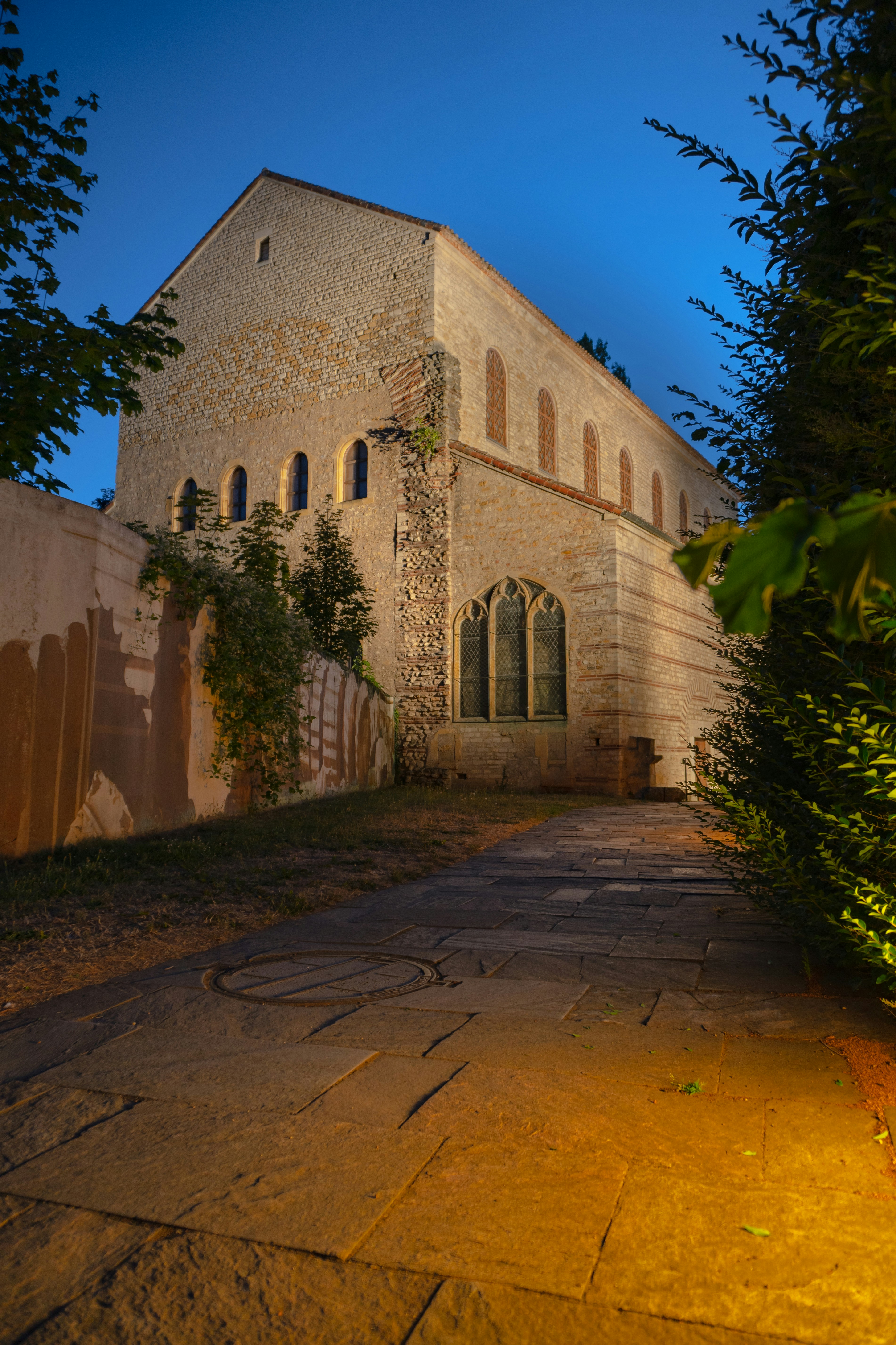 Warm evening light on a stone church along a sunlit path