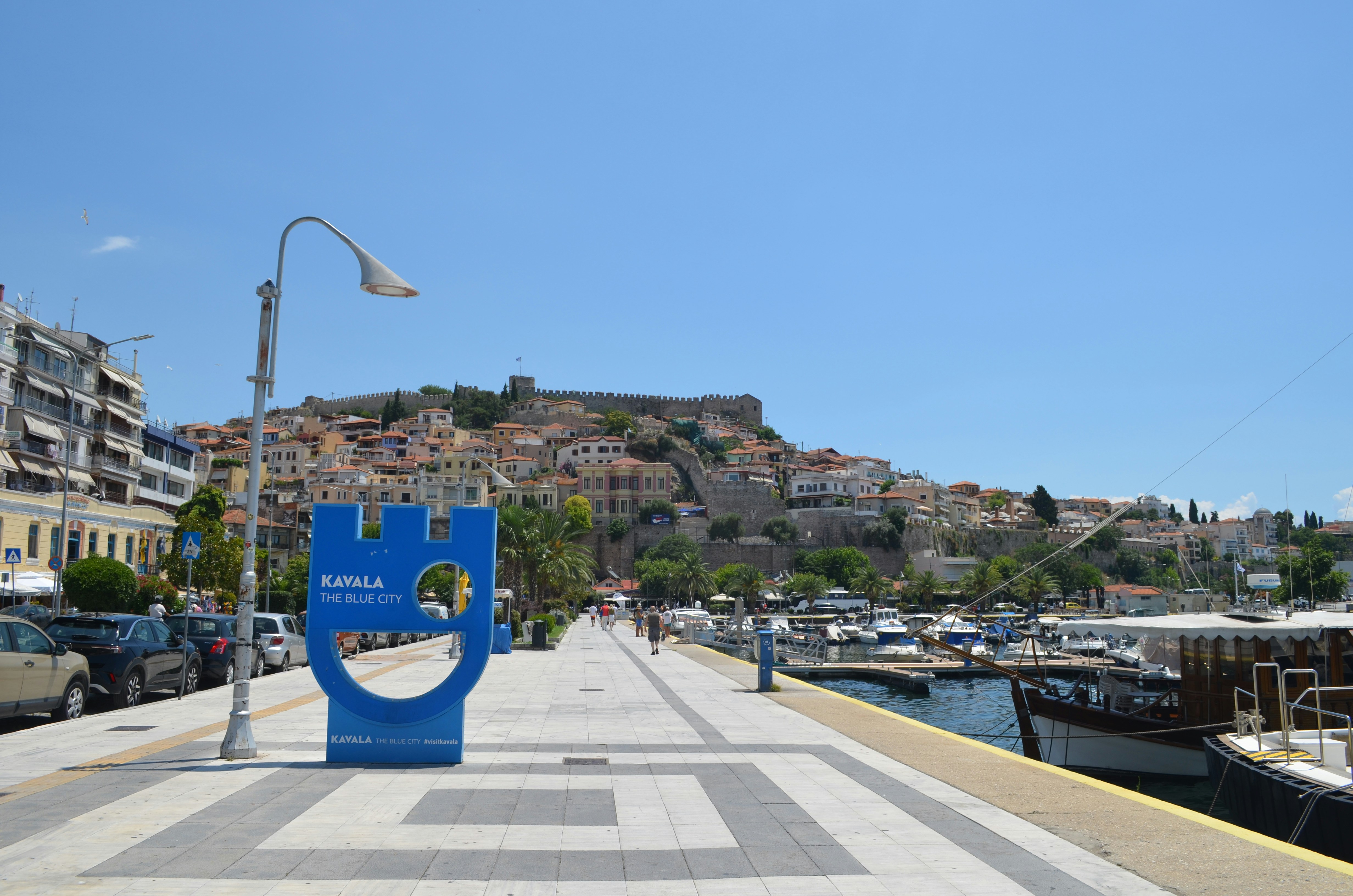 Blue keystone of the promenade: a harbor town unfurls along the hill