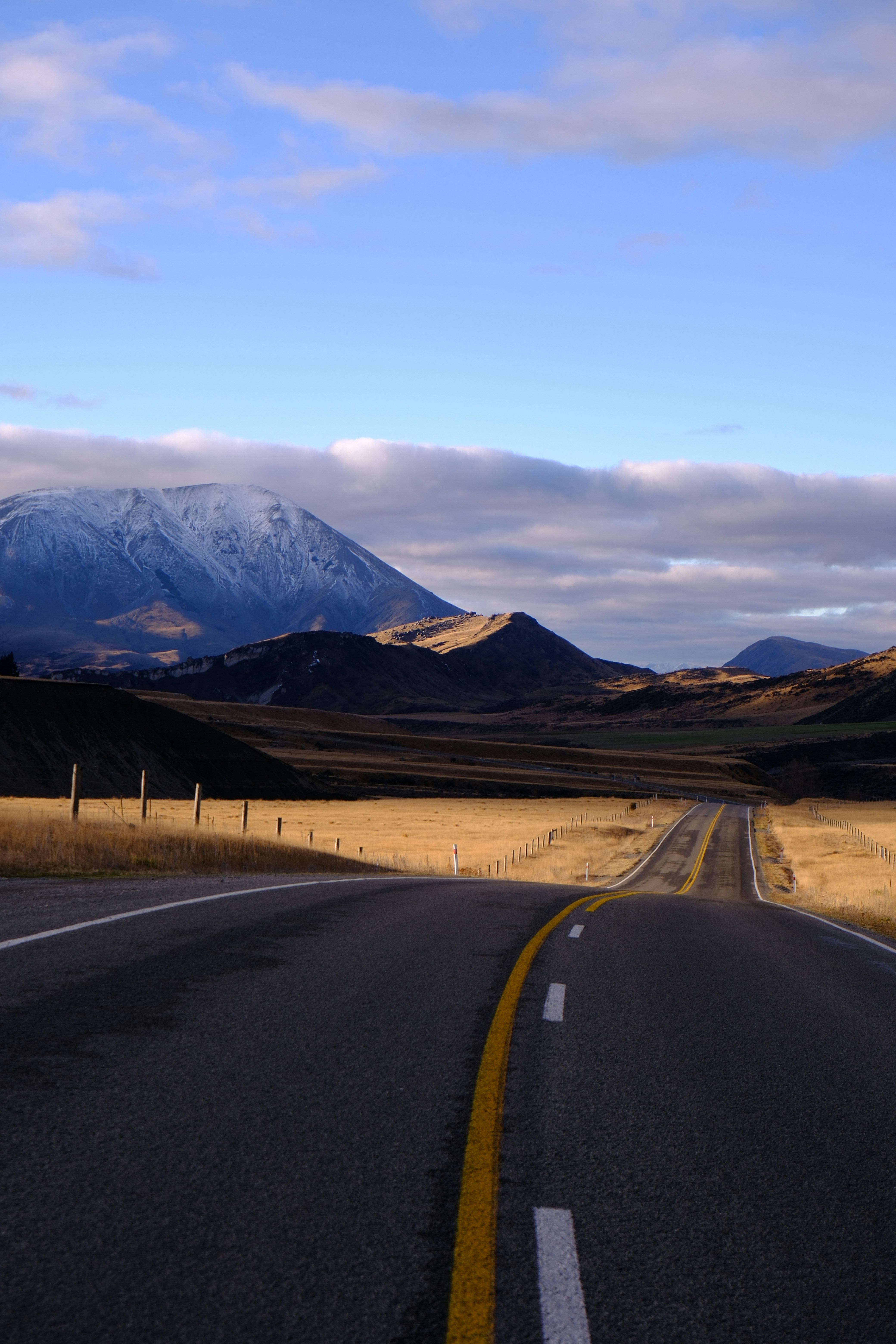 Open Highway Toward Snow-Capped Peaks at Dusk