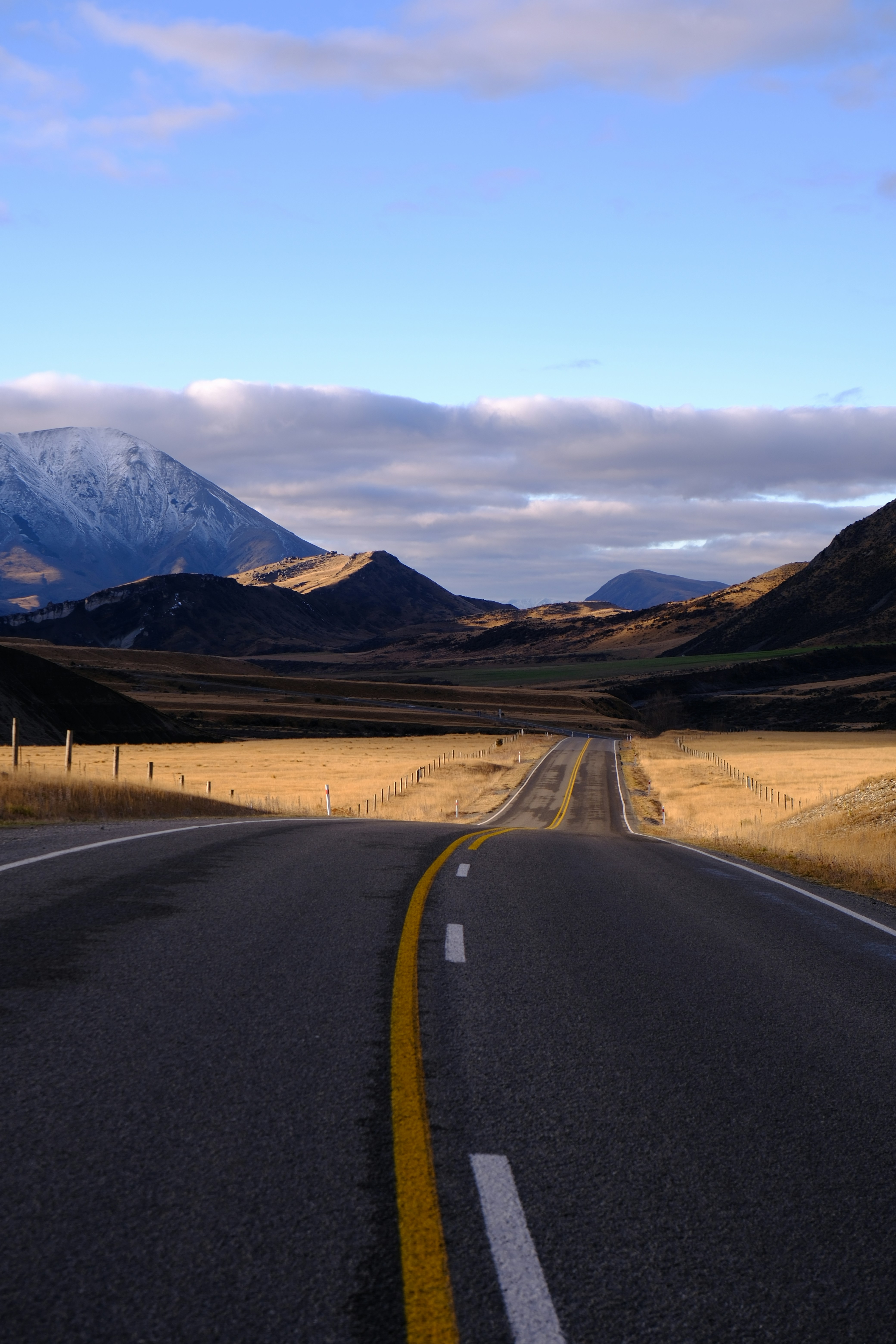Long Horizon: A Quiet Road Through Golden Valleys Under Snow-Capped Peaks