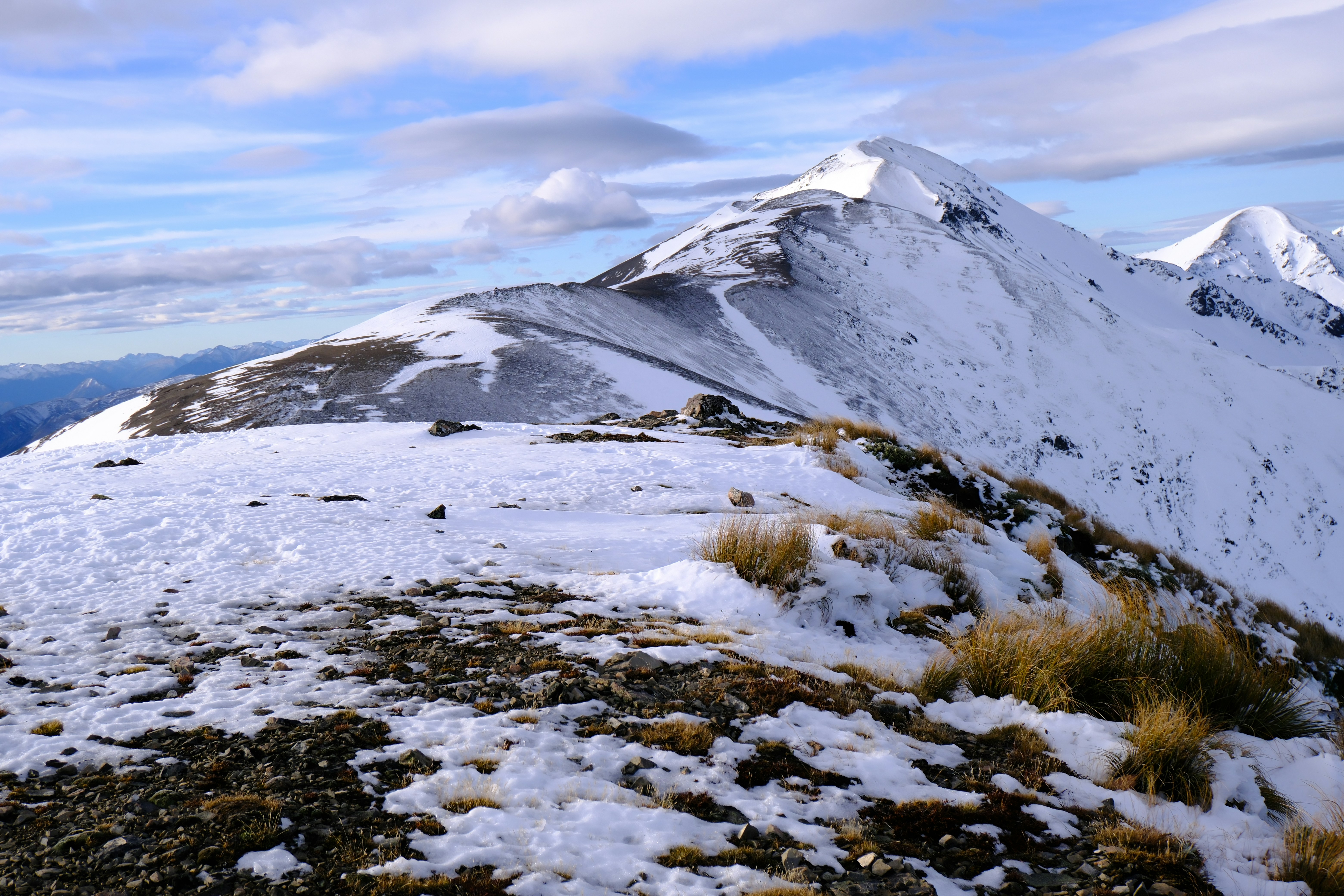 Snow-kissed ridge beneath a pale blue sky