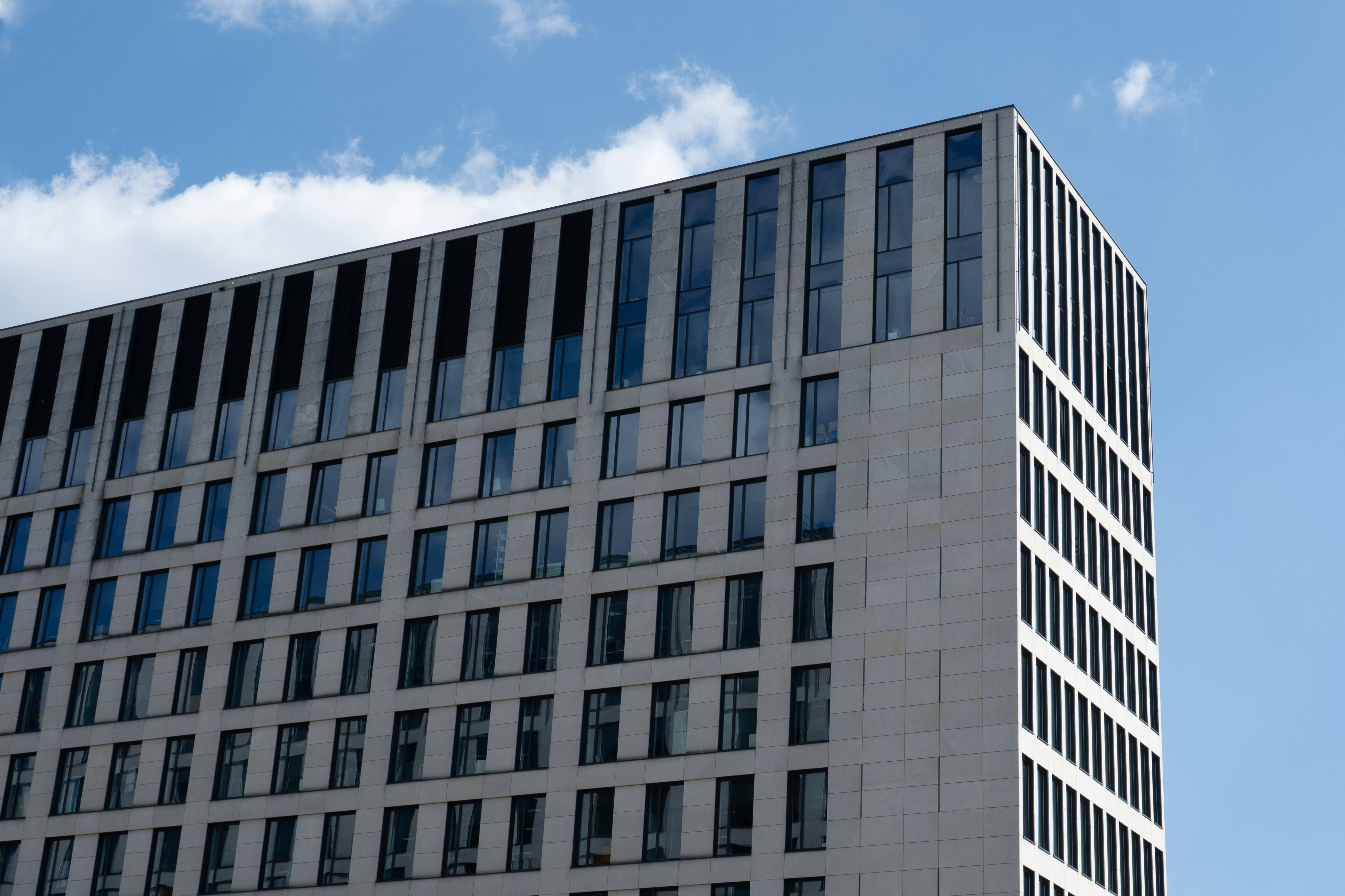 Corner Facade of a Modern Office Tower Against a Clear Sky