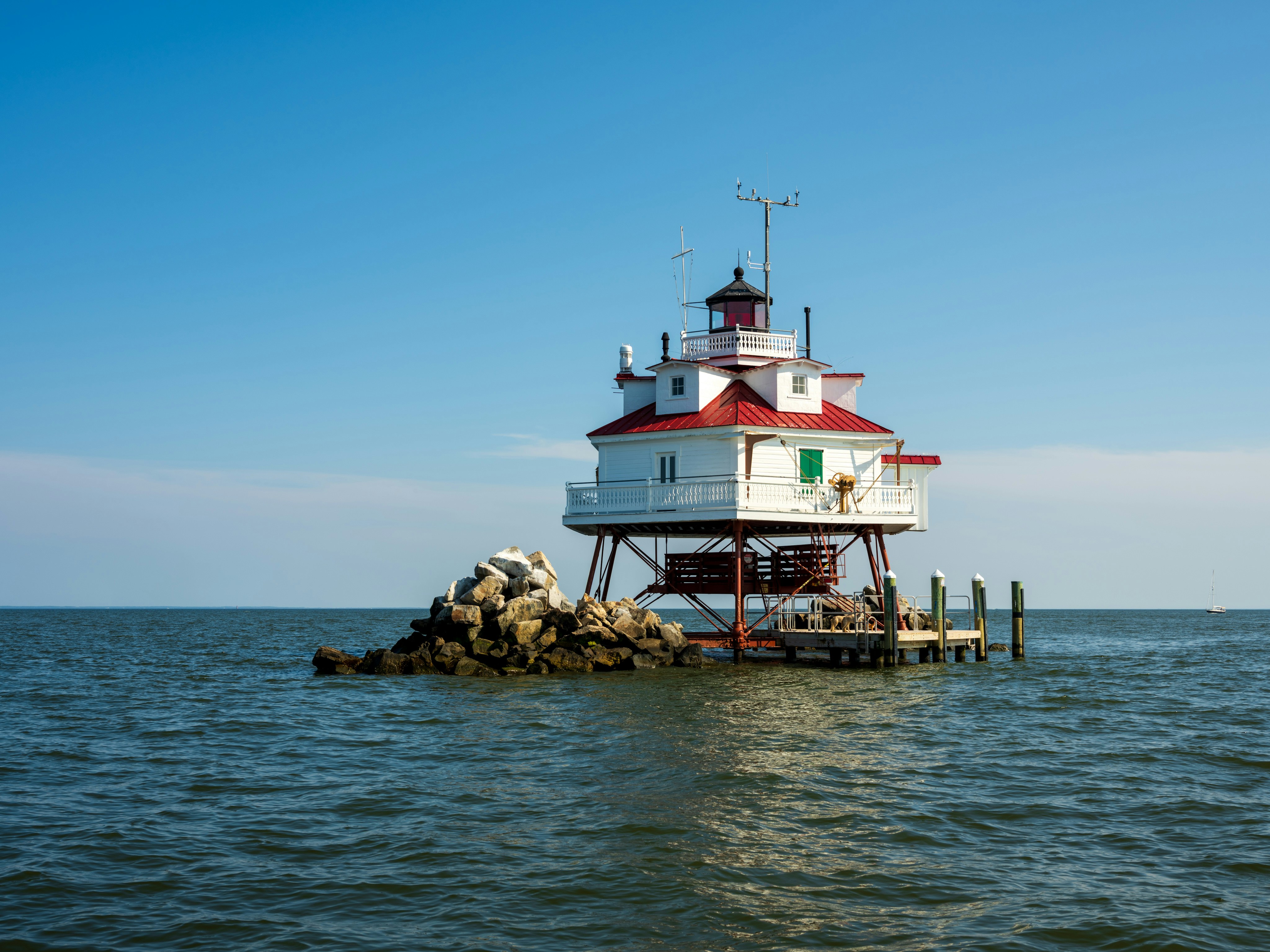 Red-roofed Lighthouse Standing on a Rock Breakwater