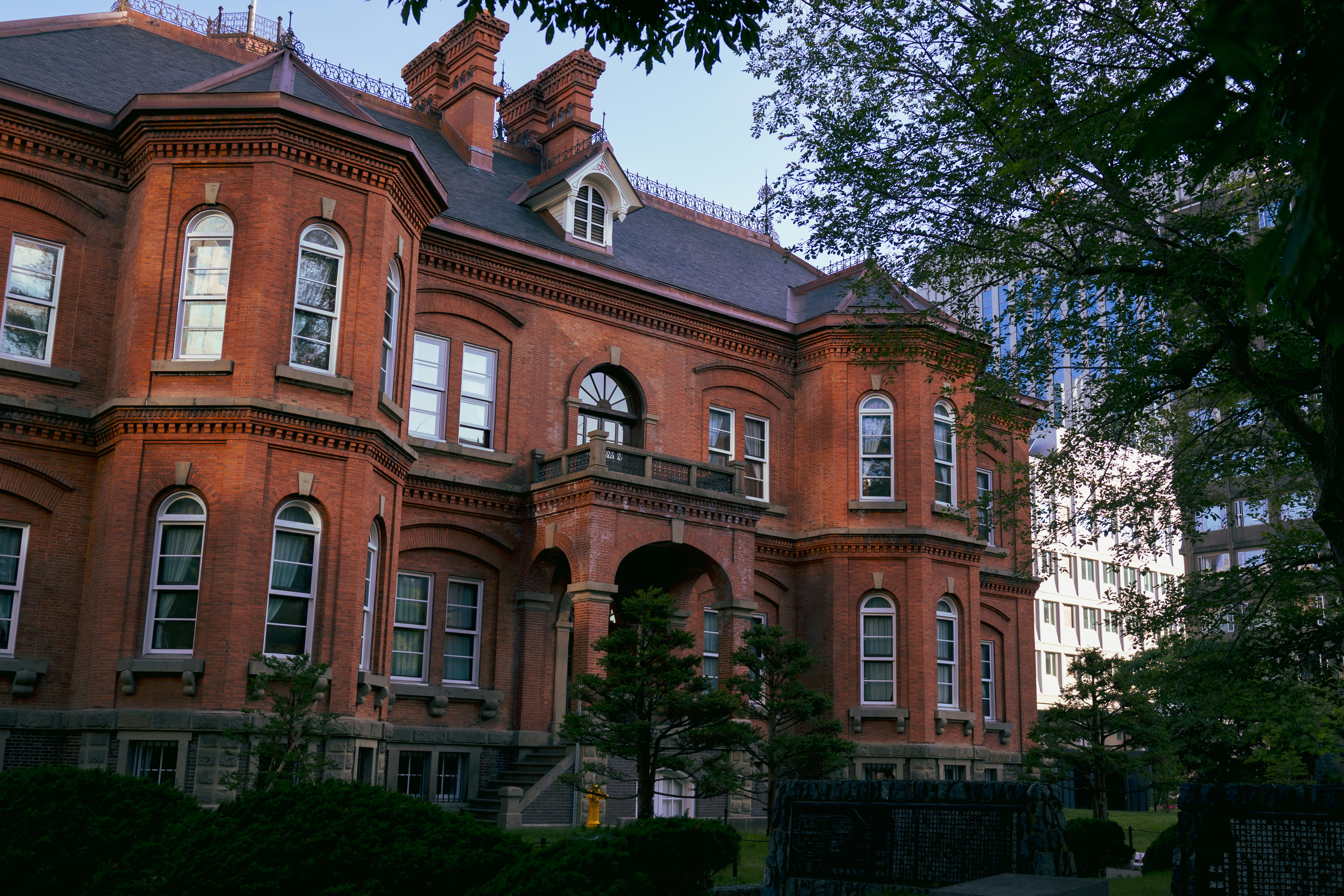 Red Brick Majesty: A University Facade Framed by Green Quiet