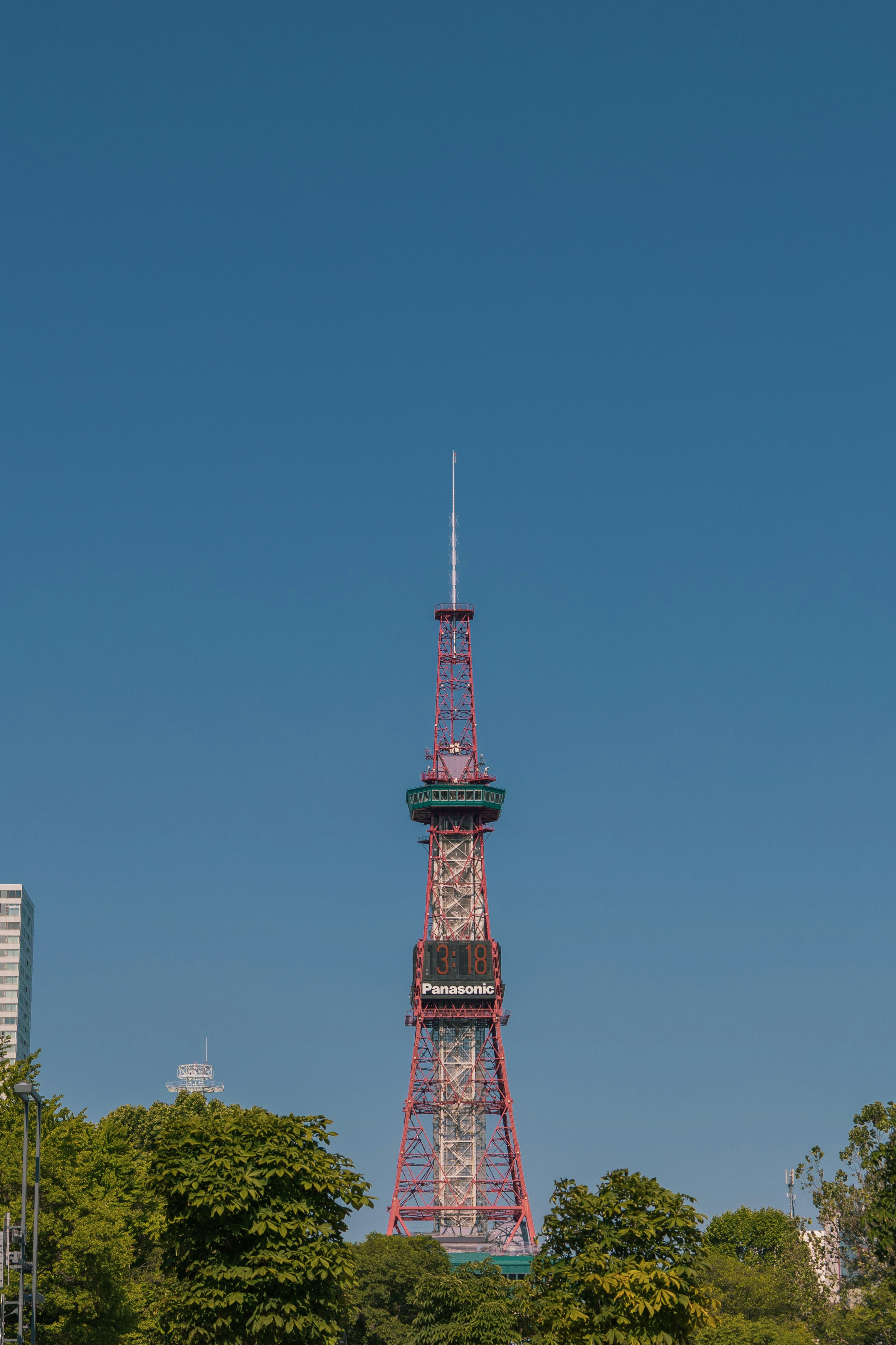 Tokyo Tower Piercing the Sky: A Clear Day Over Green Canopies