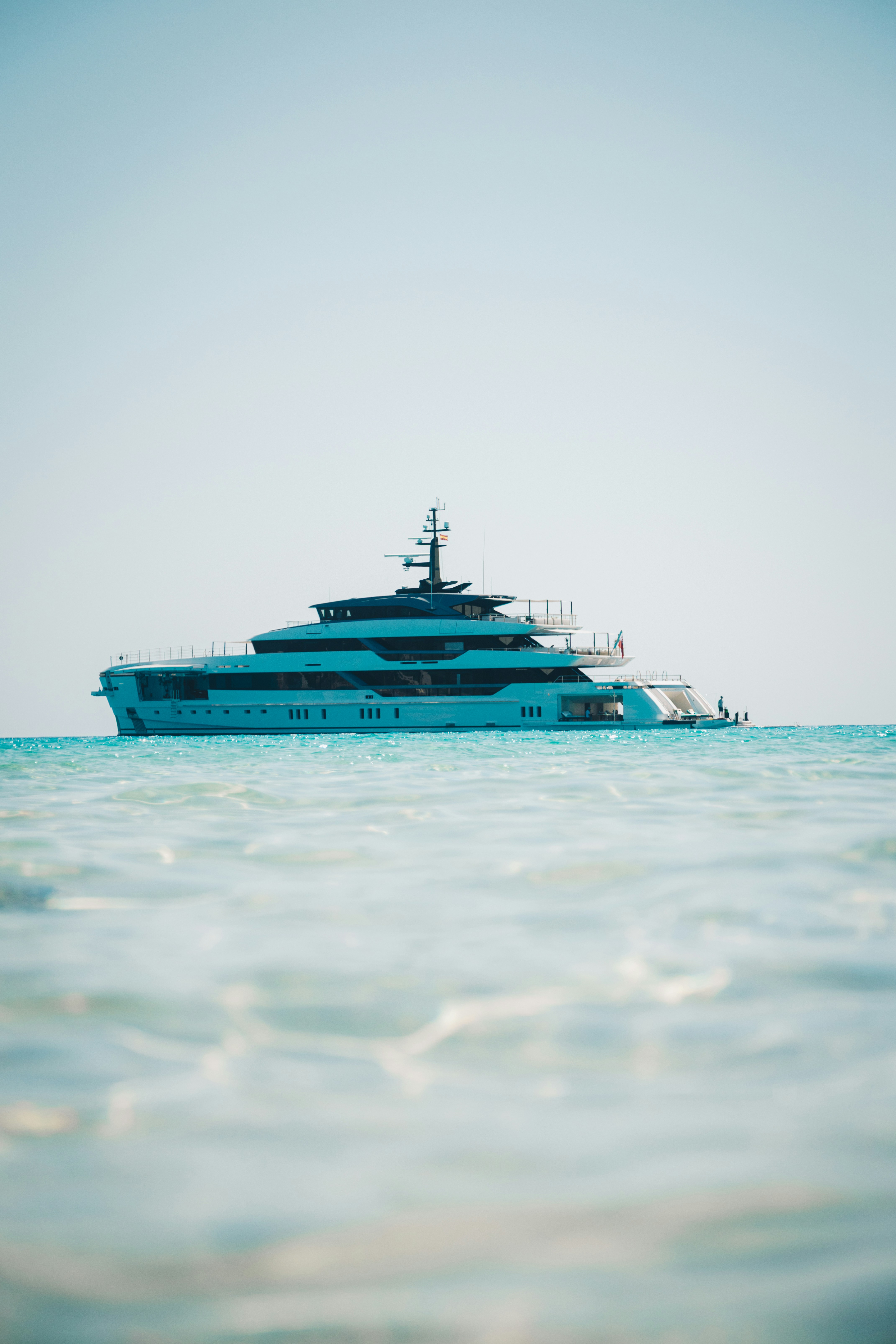High Seas Silhouette: A Luxury Yacht on Calm Turquoise Waters
