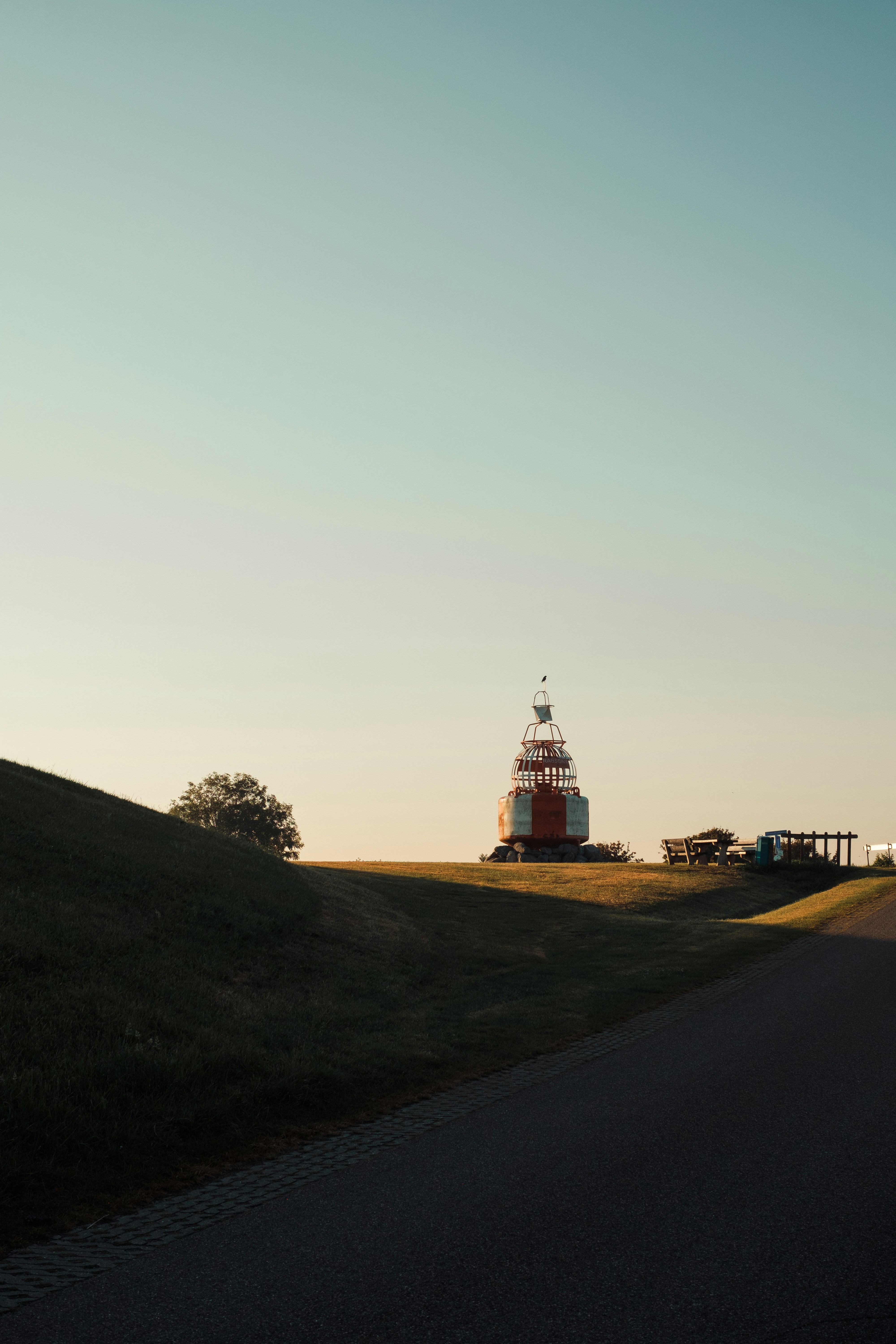 Lighthouse on the Hill: A Quiet Scene at Sunset