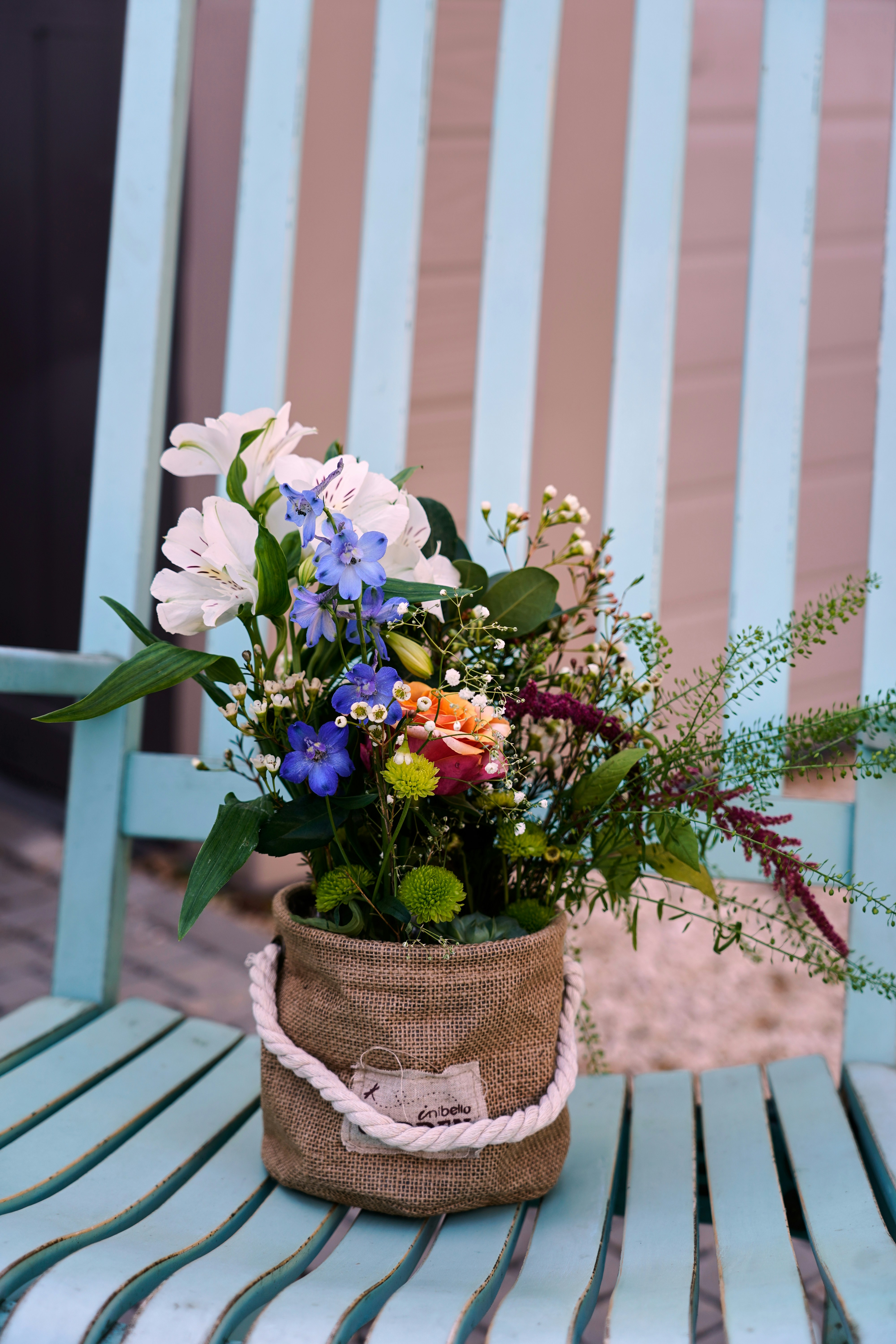 A Burlap Bloom Basket on a Serene Teal Bench
