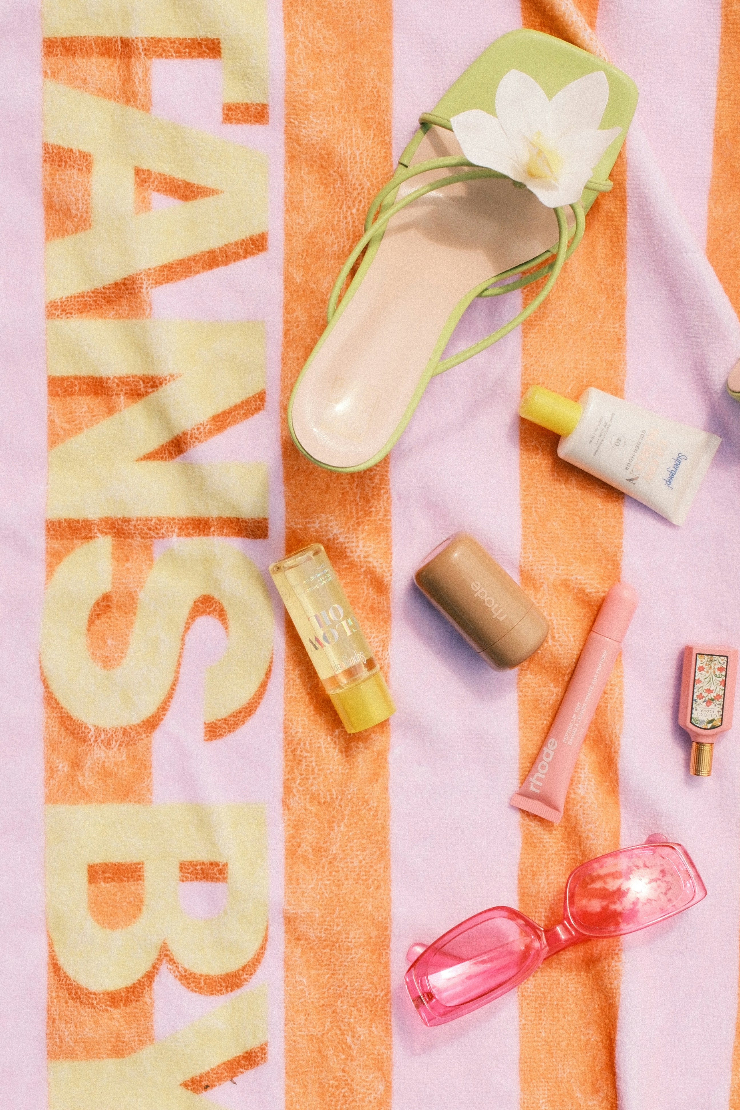 Sunlit Spa Essentials on a Striped Beach Towel