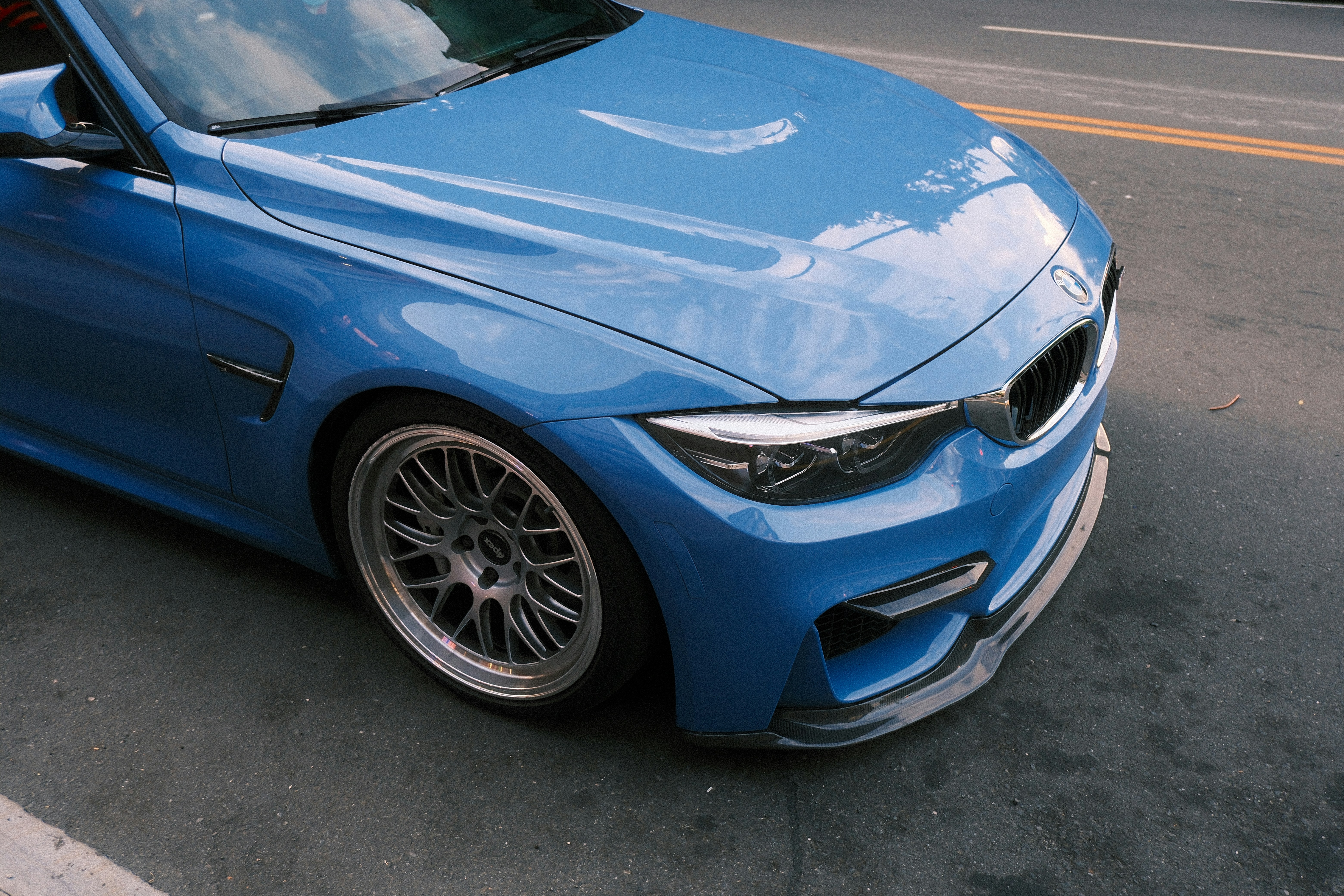 Blue BMW Stance: Close-up of a lowered front-left shot with aggressive wheel and bumper details