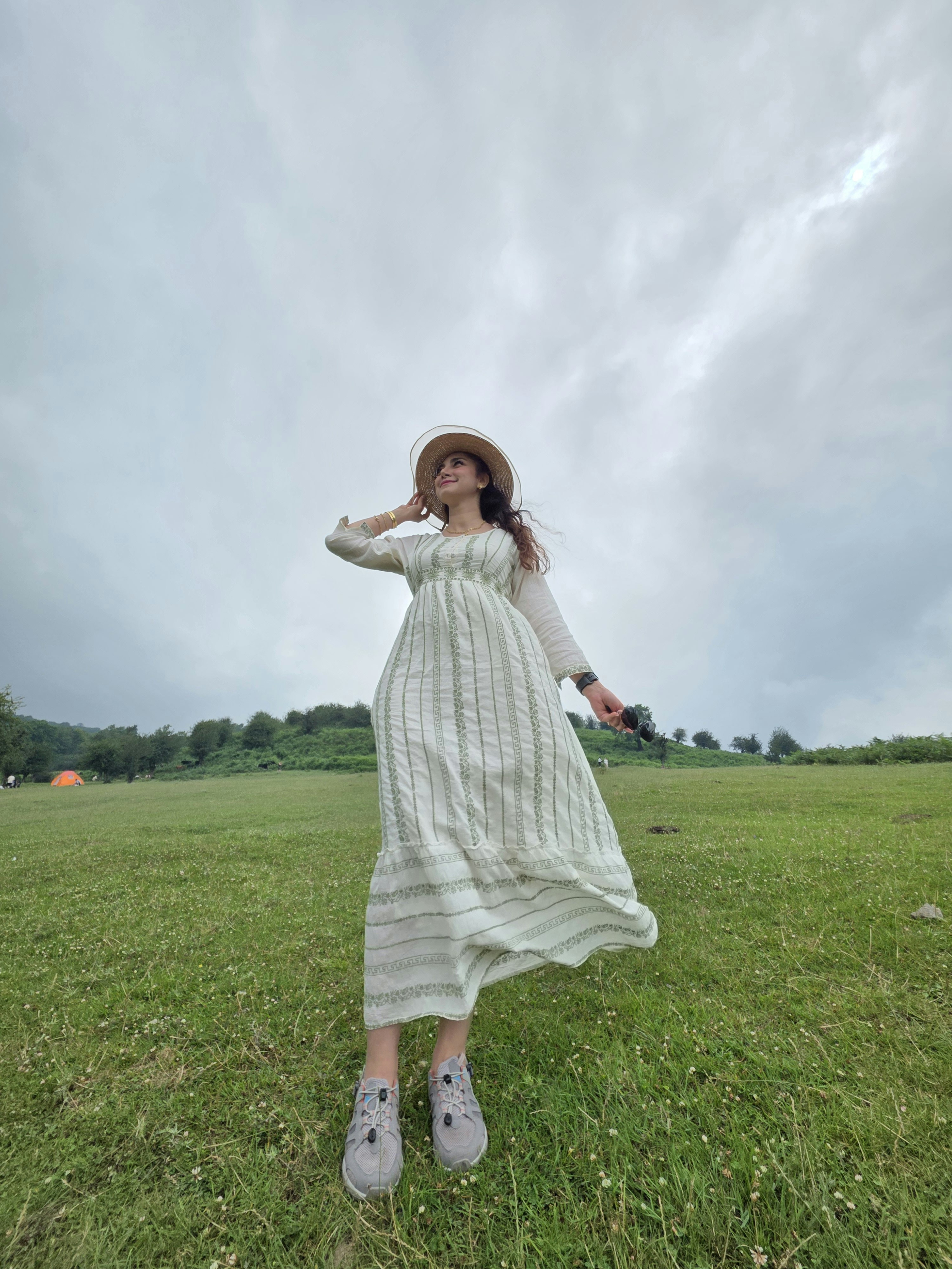 Floating in a Spring Field: A Woman in a White Dress Beneath a Wide Sky