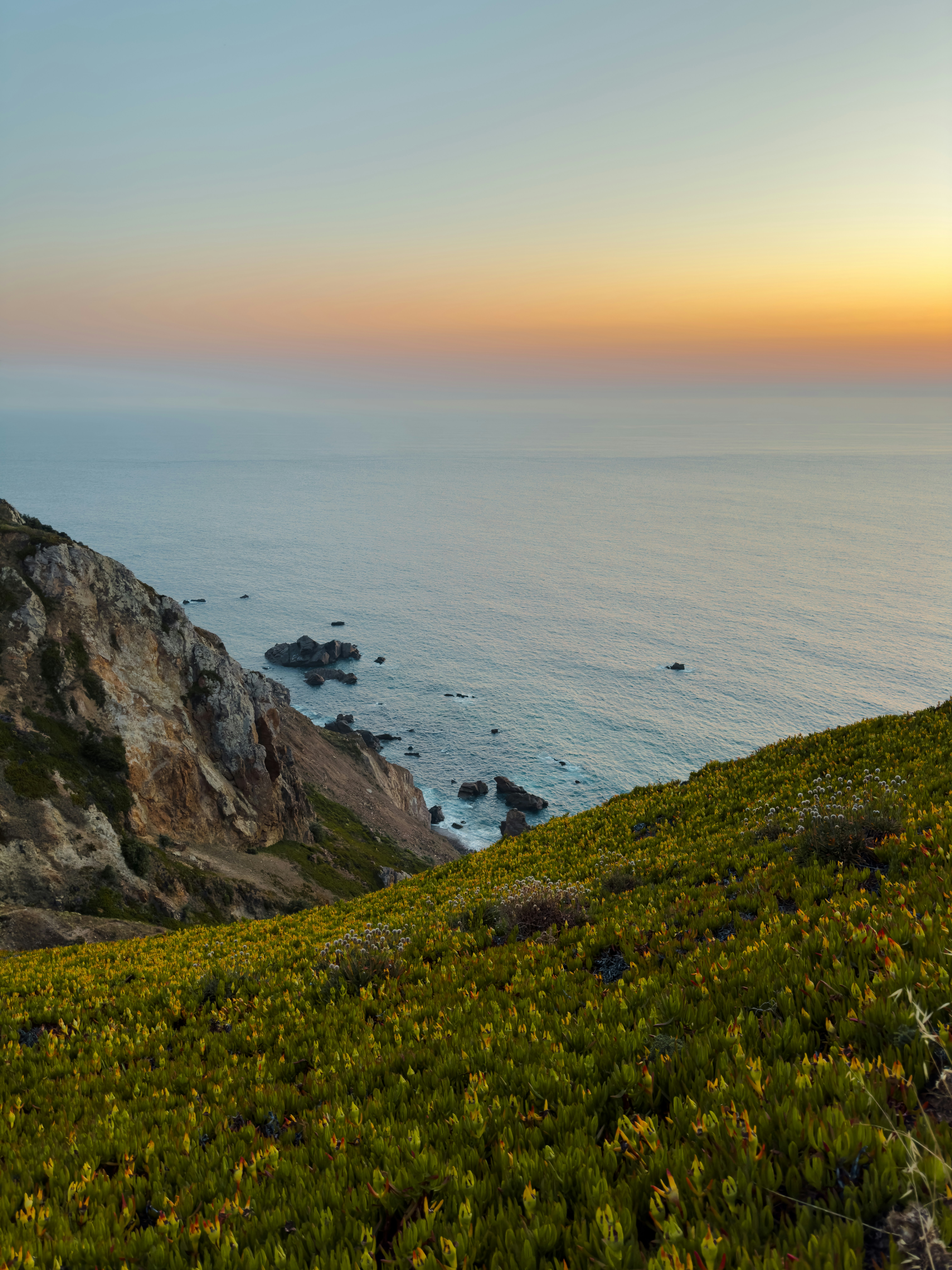 Sunlit hillside Overlooking the Quiet Sea at Dusk