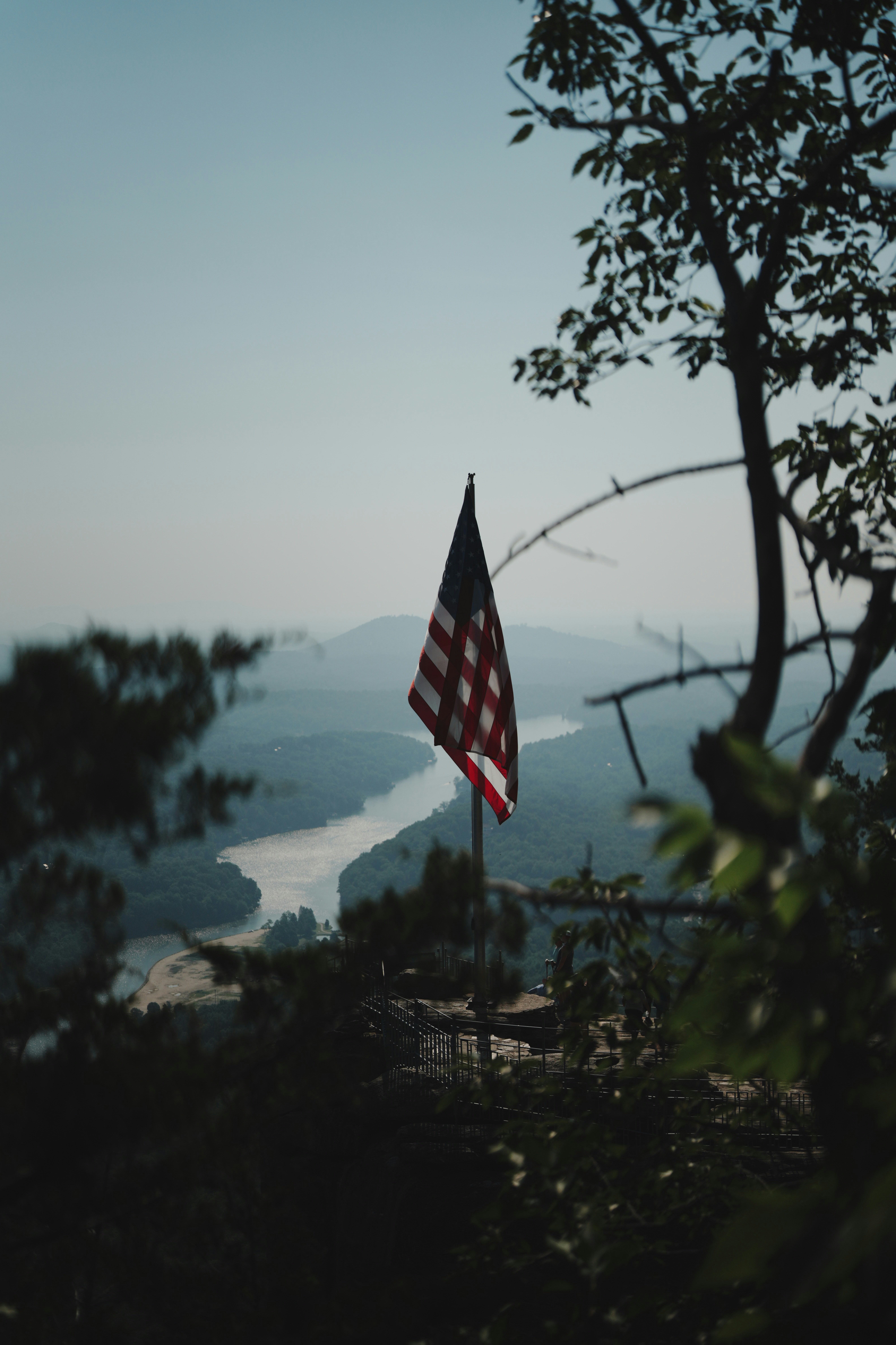 Flag on a Quiet Ridge: A Distant River and Silhouetted Trees