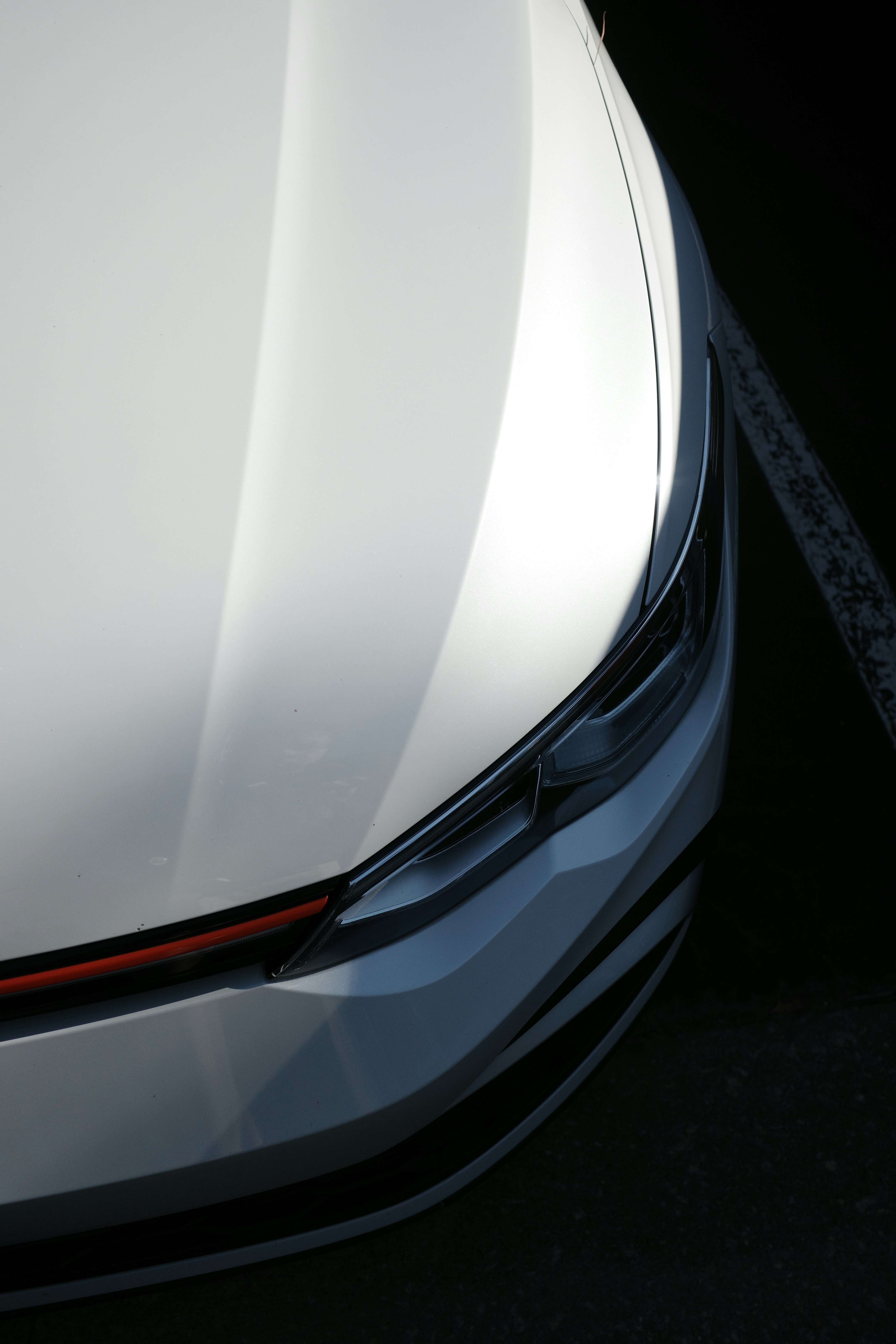 Chrome Edge in the Shadow: A Close-Up of a Car Front