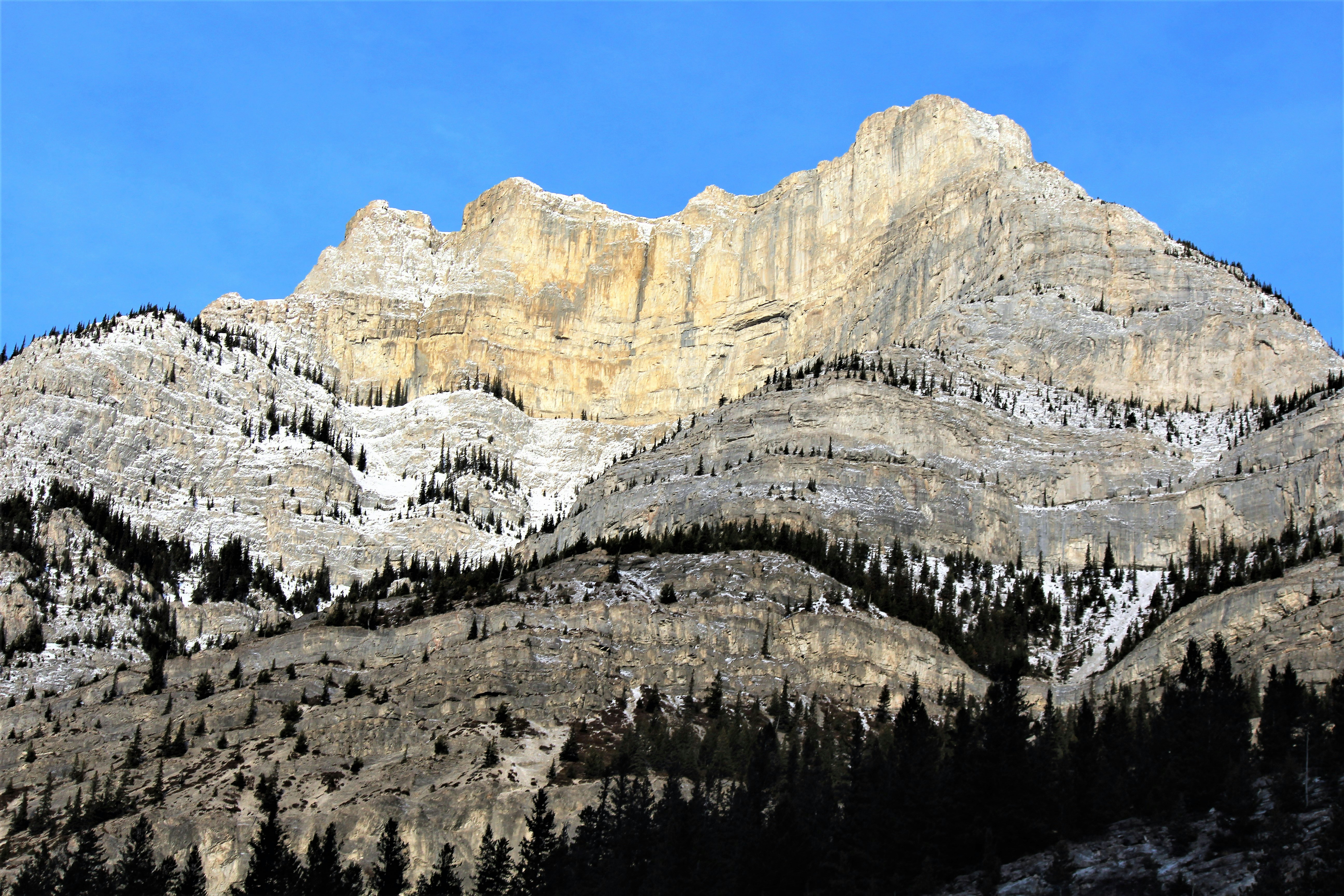 Light on the Peak: A Snow-dusted Face Reaches for the Blue Sky