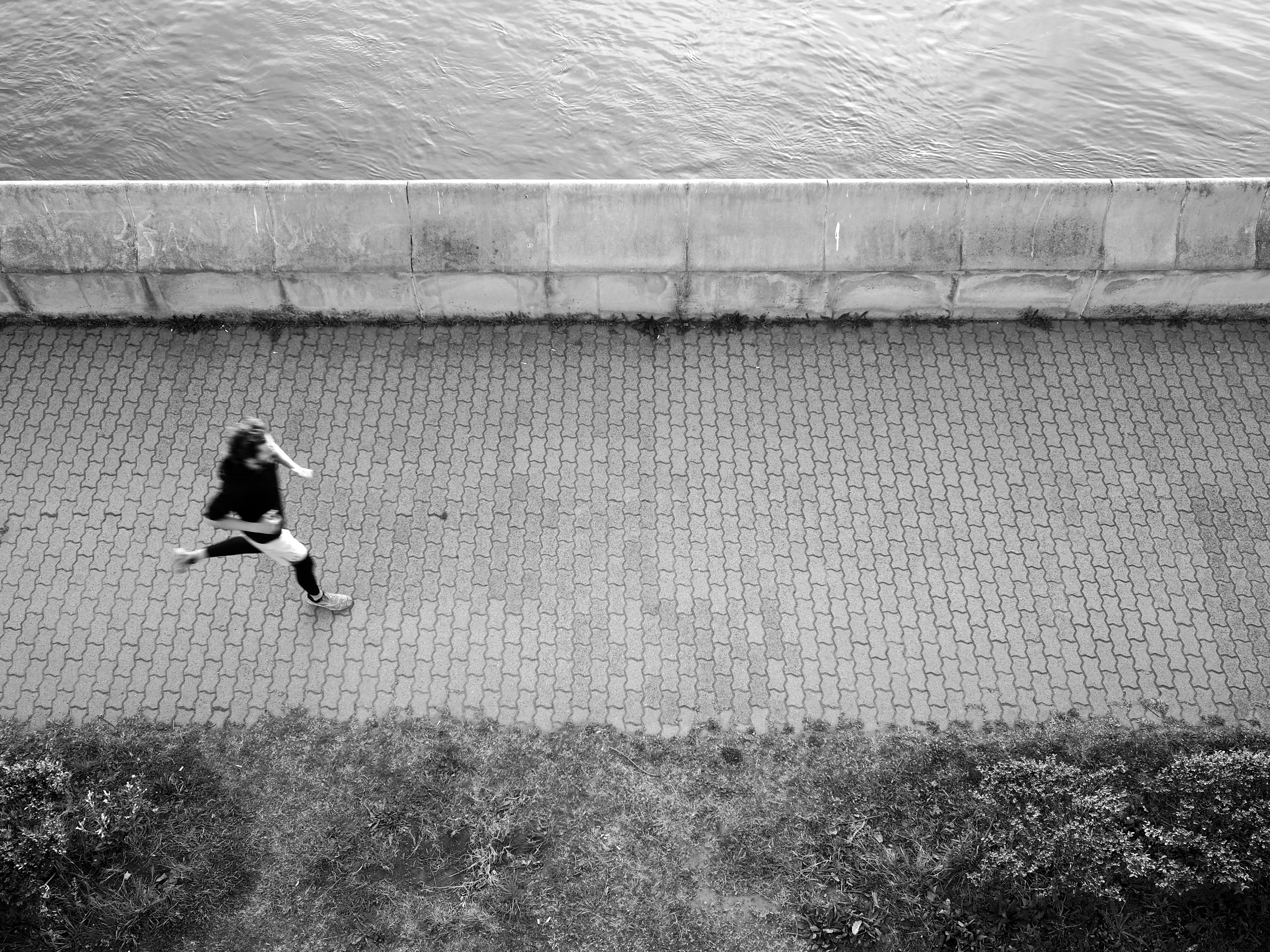 A lone pedestrian traverses the canal-side promenade