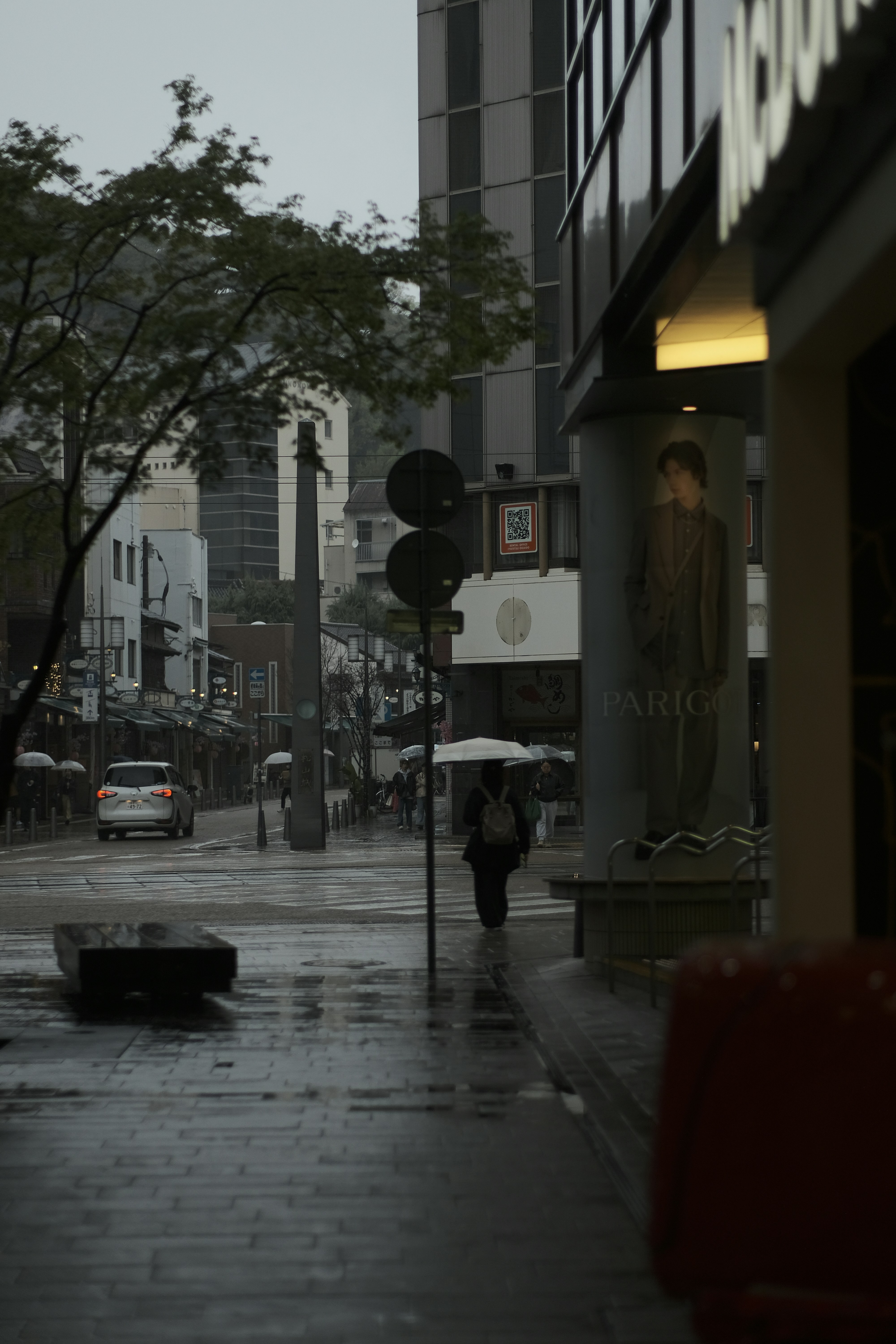 Rainy urban stroll toward a quiet corner store