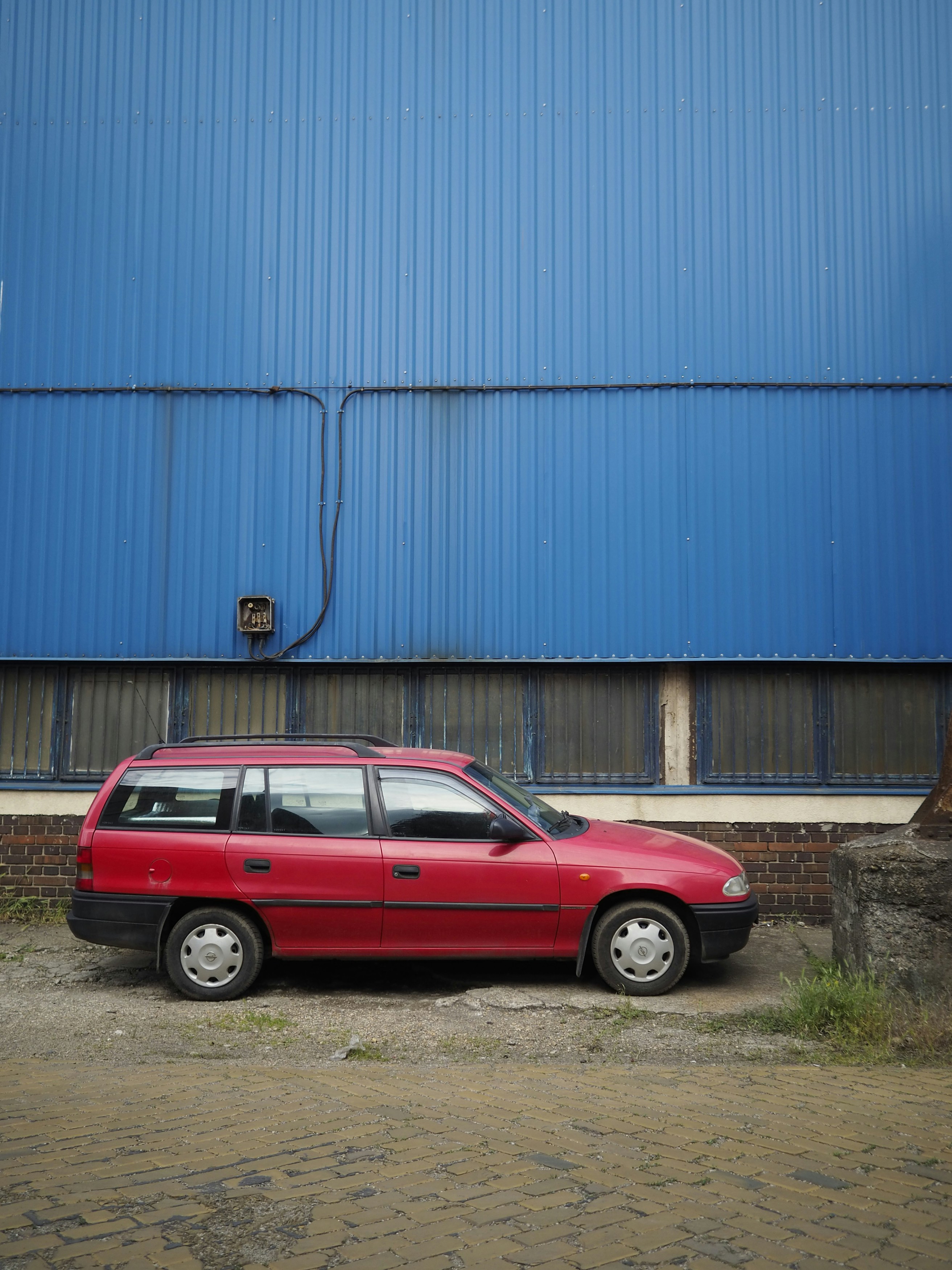 Red Wagon in Front of a Bold Blue Facade