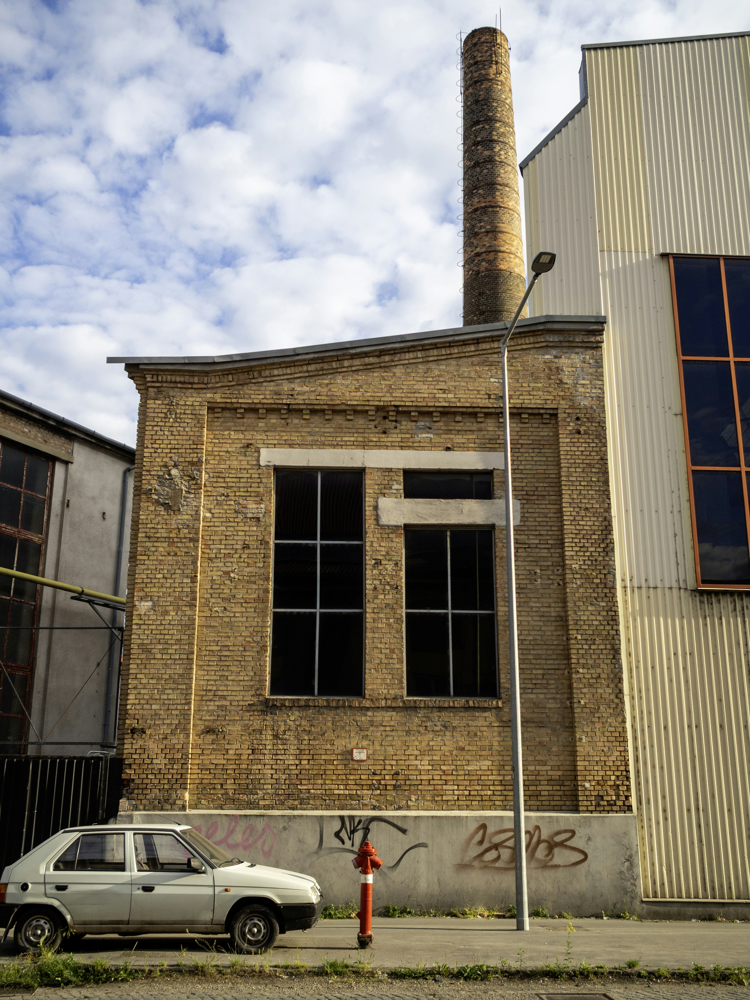 Brick Factory Facade with Weathered Window and Street Scene