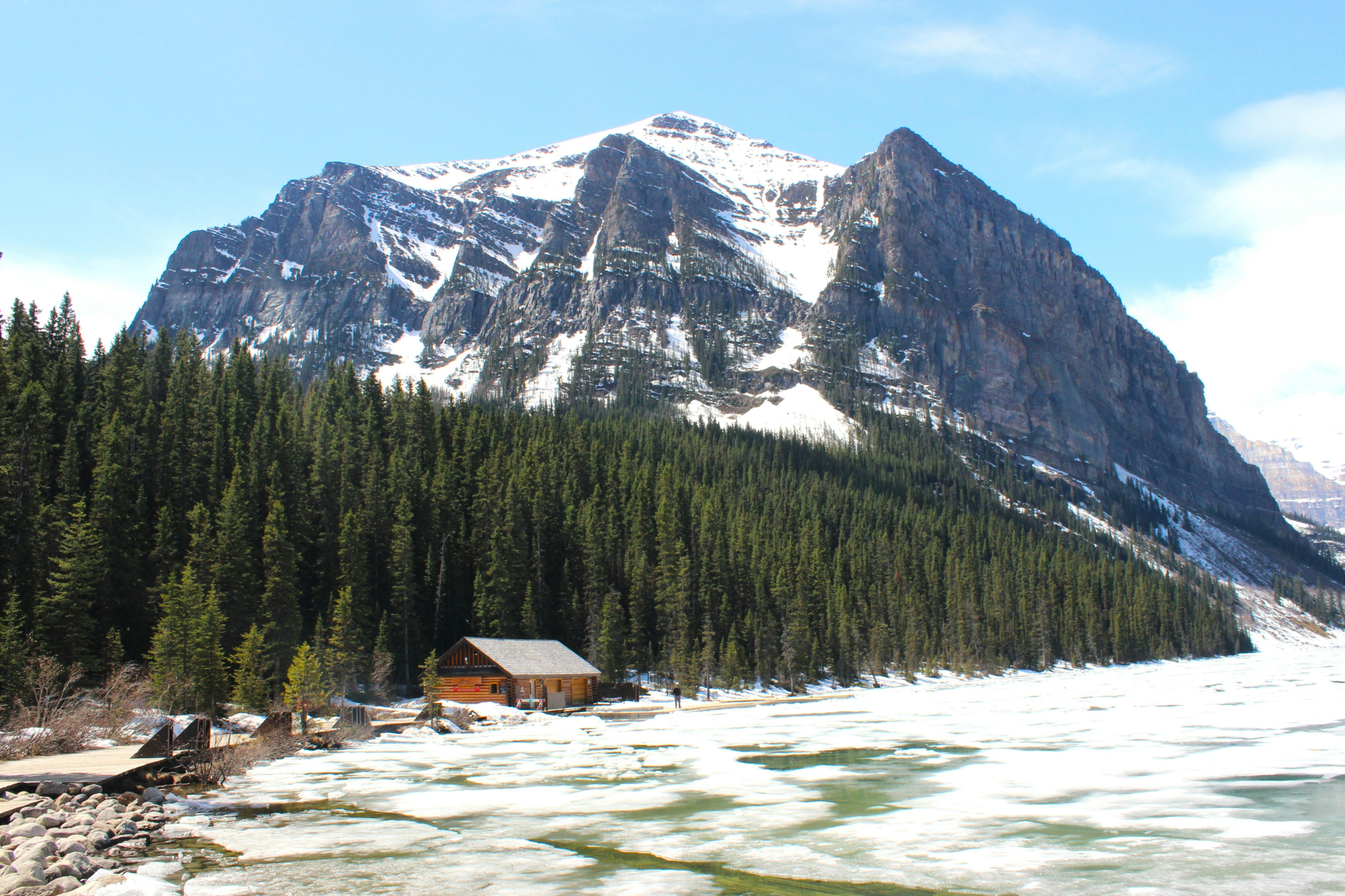 Snow-Trimmed Peak Over a Quiet Cabin by Icy Shore