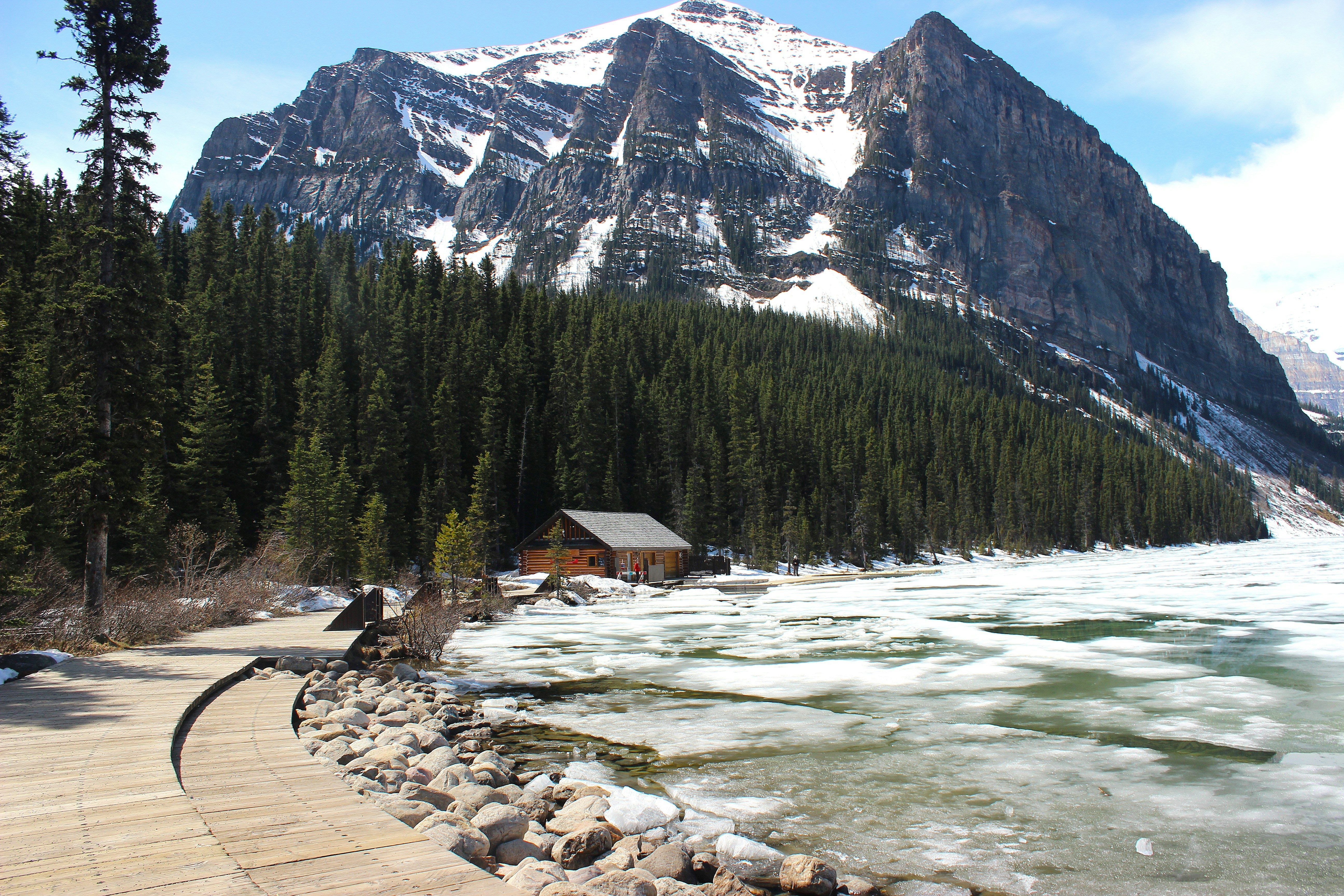 Trailside View of a Snow-Mlicked Lake and Rugged Mountain