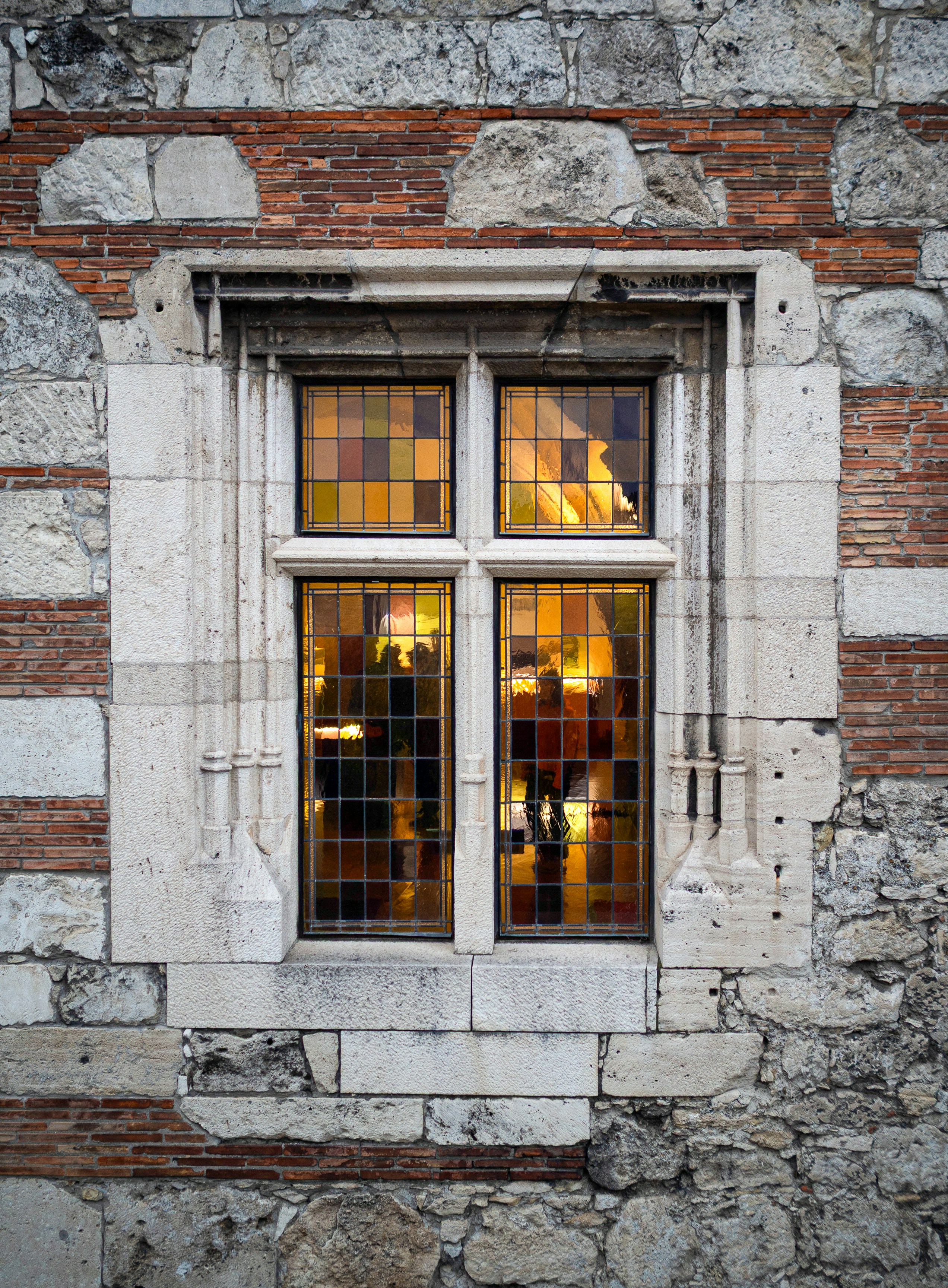 Sunlit Gothic Window: Warm interiors through a stone-framed pane