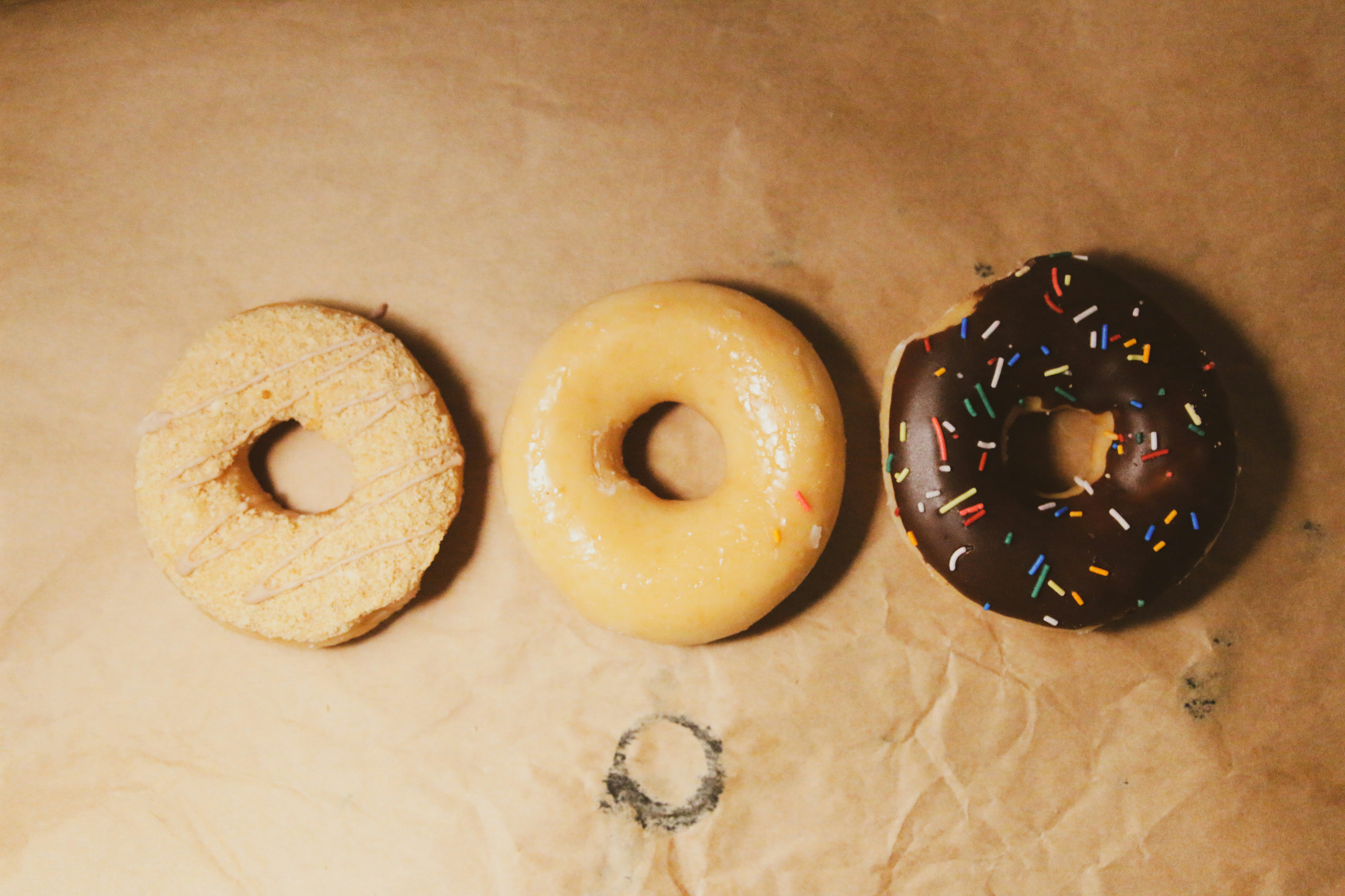 Tri-Donut Trio on Crumpled Pastry: A Quiet Bite of Color