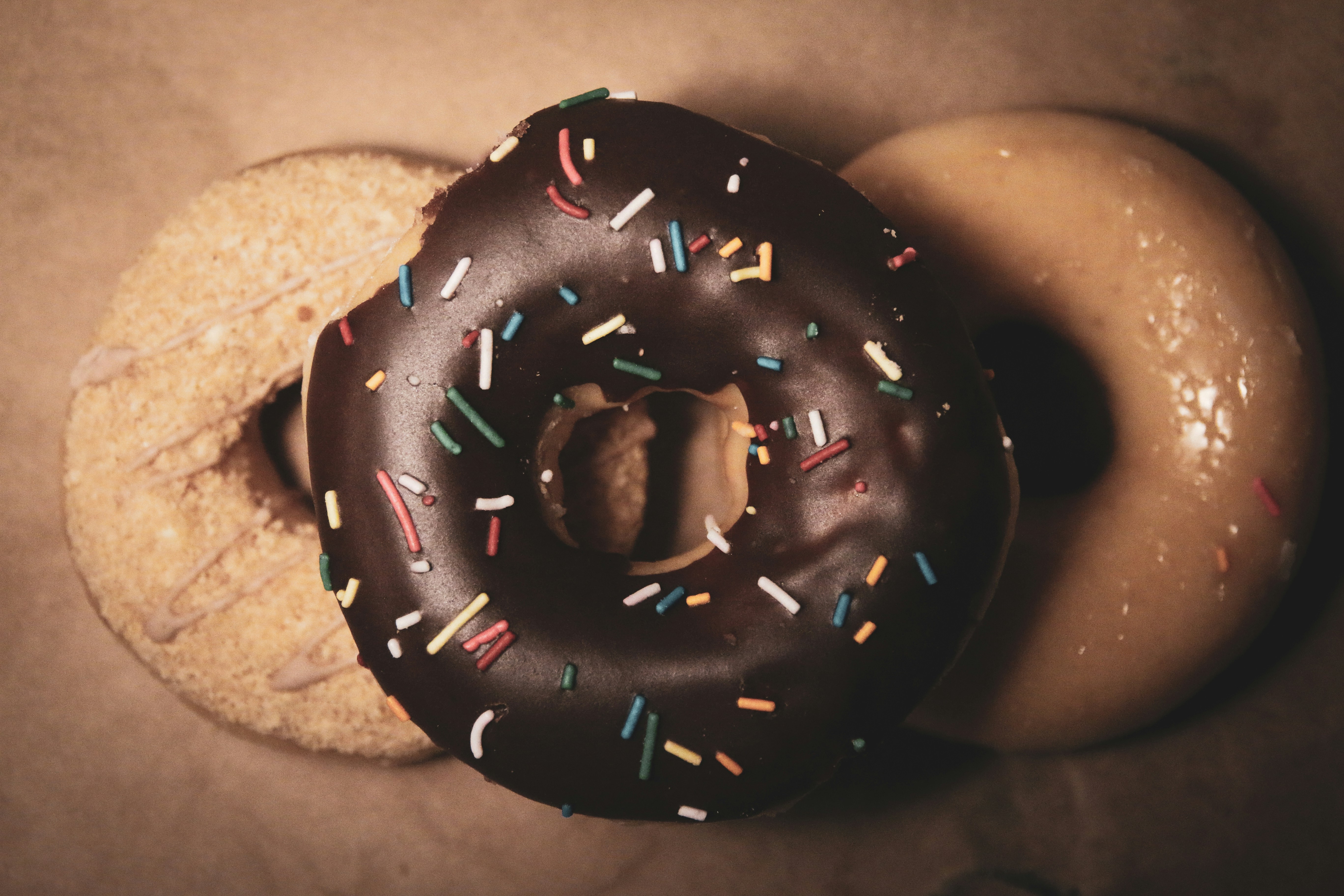 Sugared Orbit: A Chocolate Donut Reigns Over a Quiet Duo
