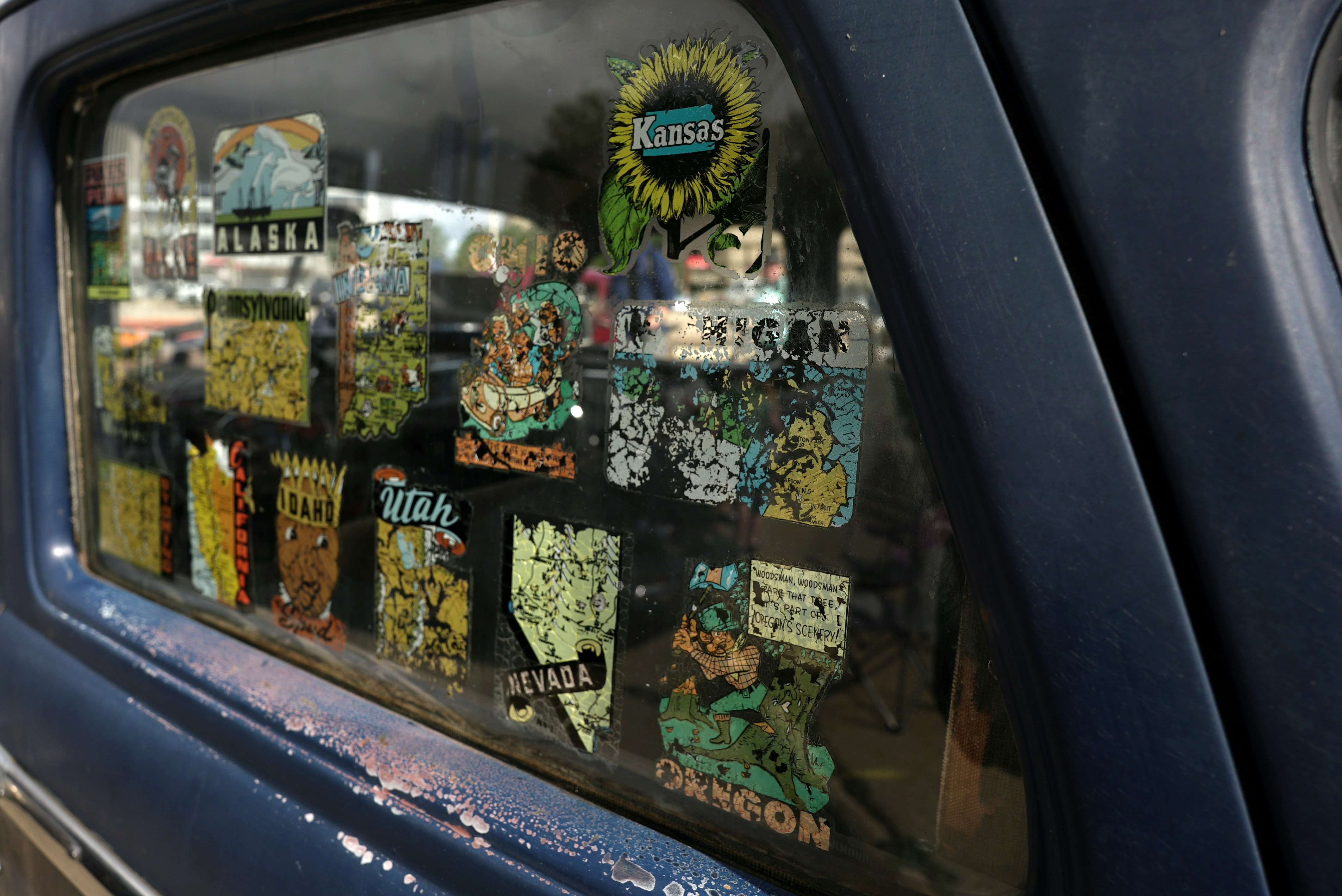 Stickers on a Weathered Car Window: A Quiet Gallery of Travel Tales