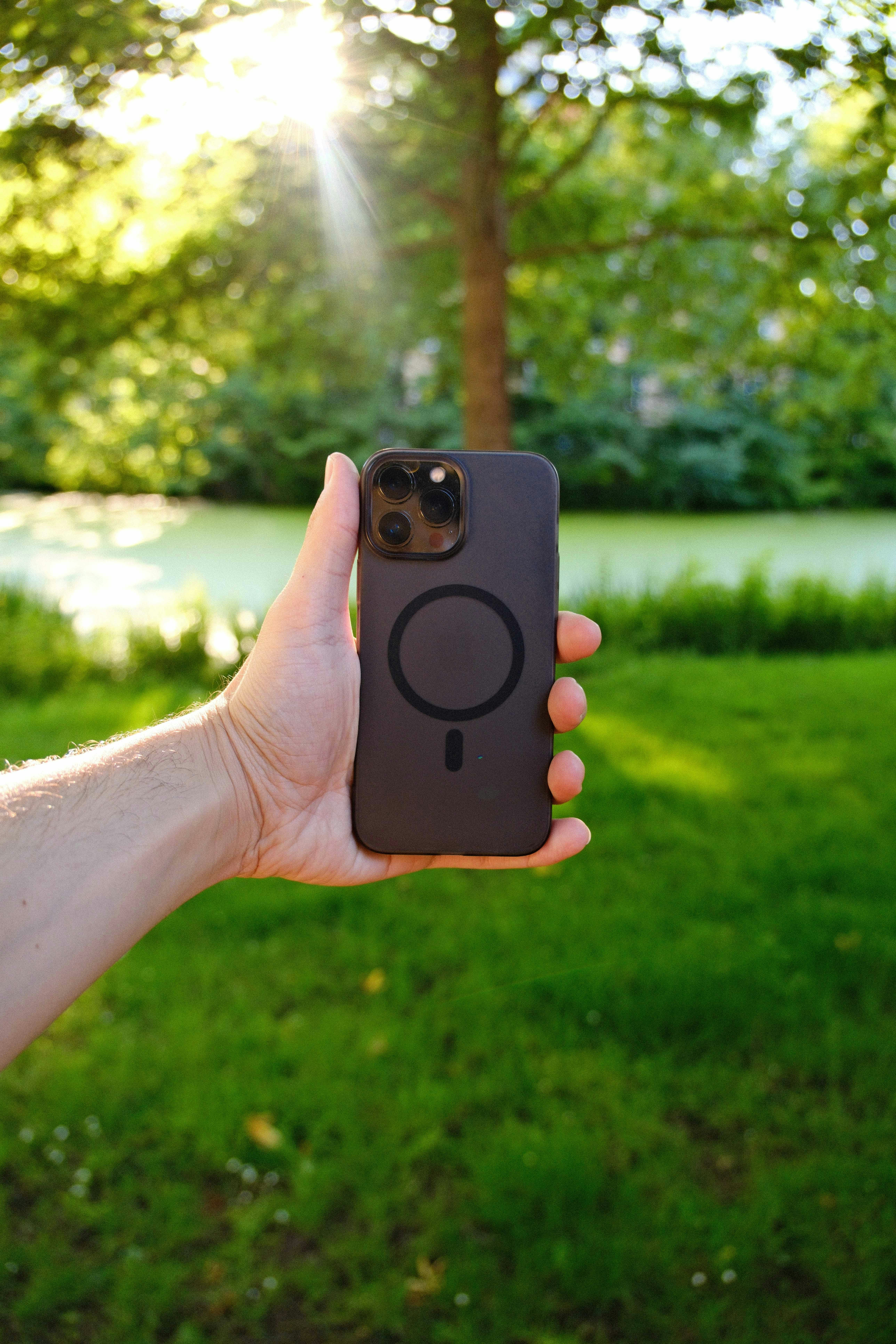 Holding the Moment: A Phone Portrait Framed by Sunlit Park