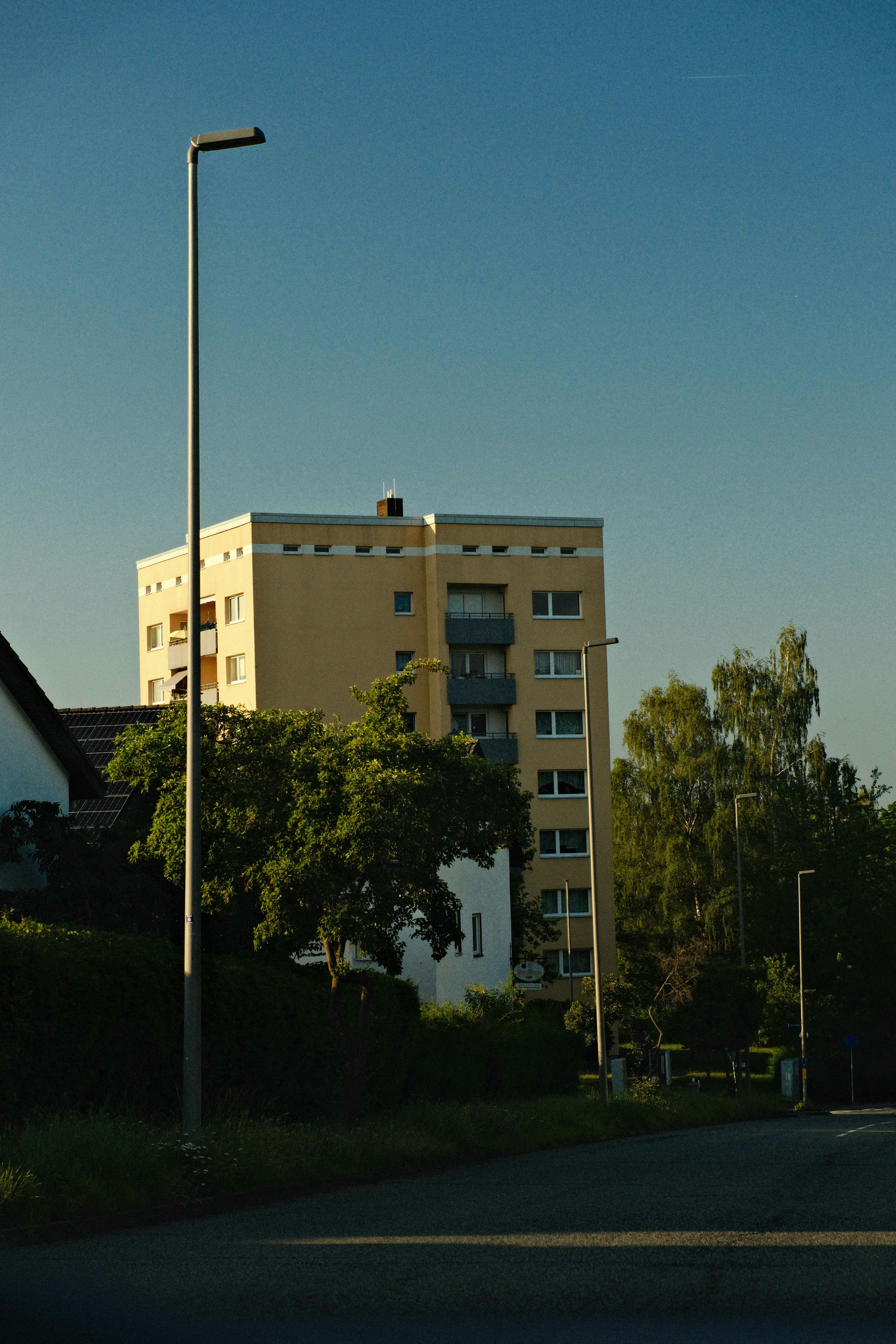 Urban Afternoon: The Yellow Apartment Amid Quiet Trees