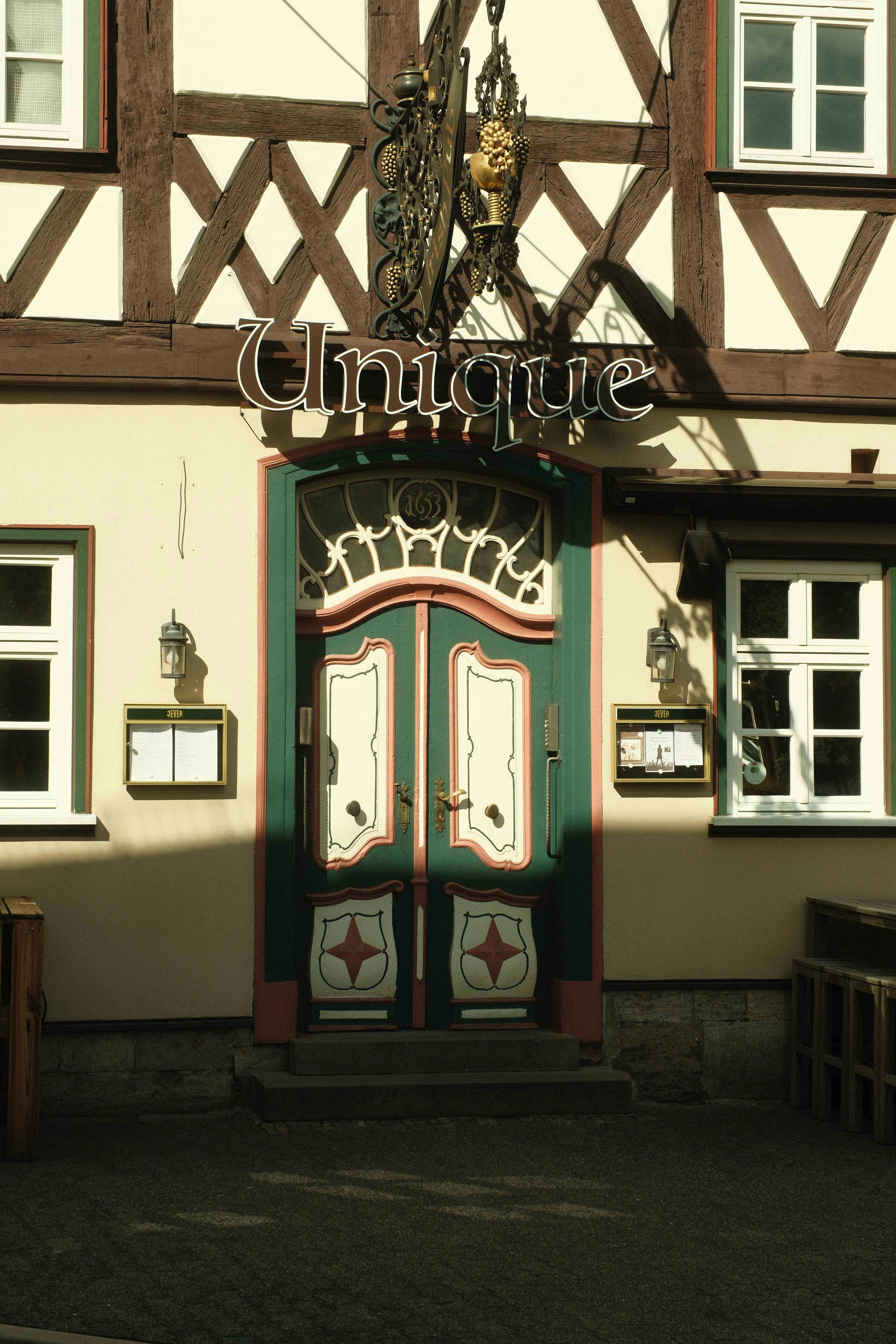Unique facade: a timber-framed entrance with ornate sign above a double door