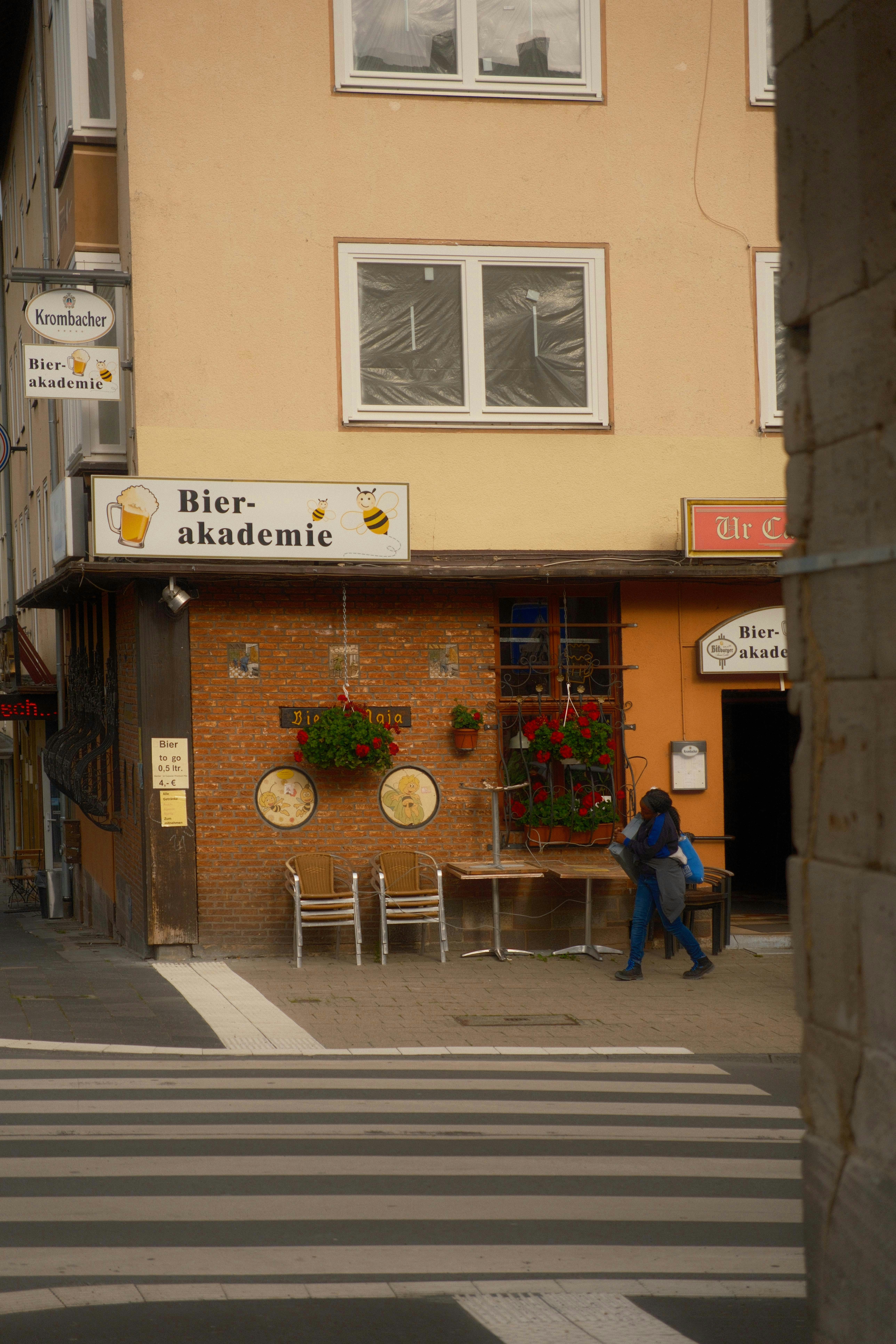 Beer Café Facade: A Street-Level Scene with a Worker Crossing
